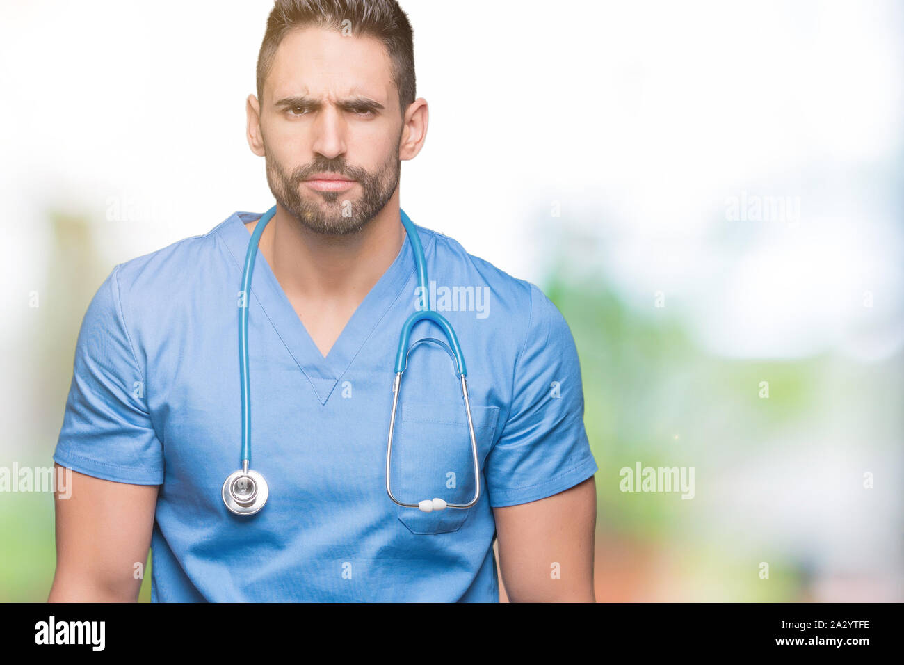 Handsome young doctor surgeon man over isolated background skeptic and ...