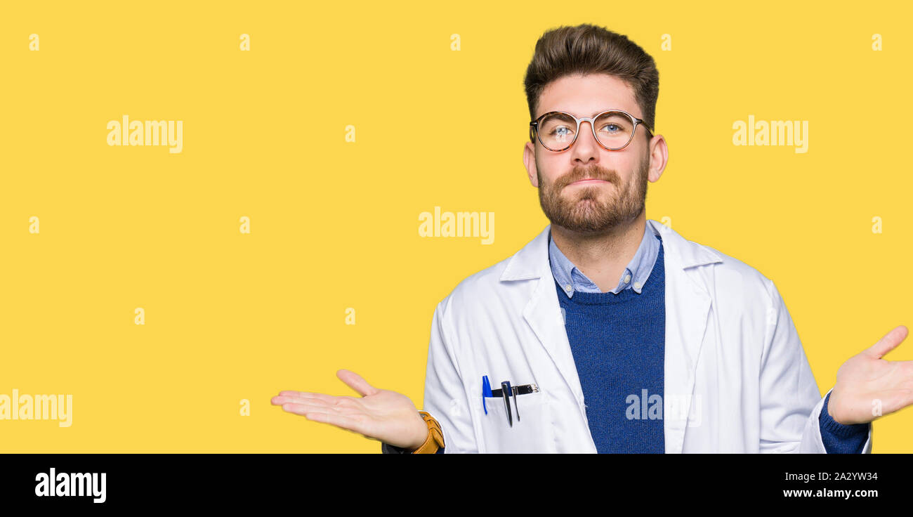 Young handsome scientist man wearing glasses clueless and confused ...