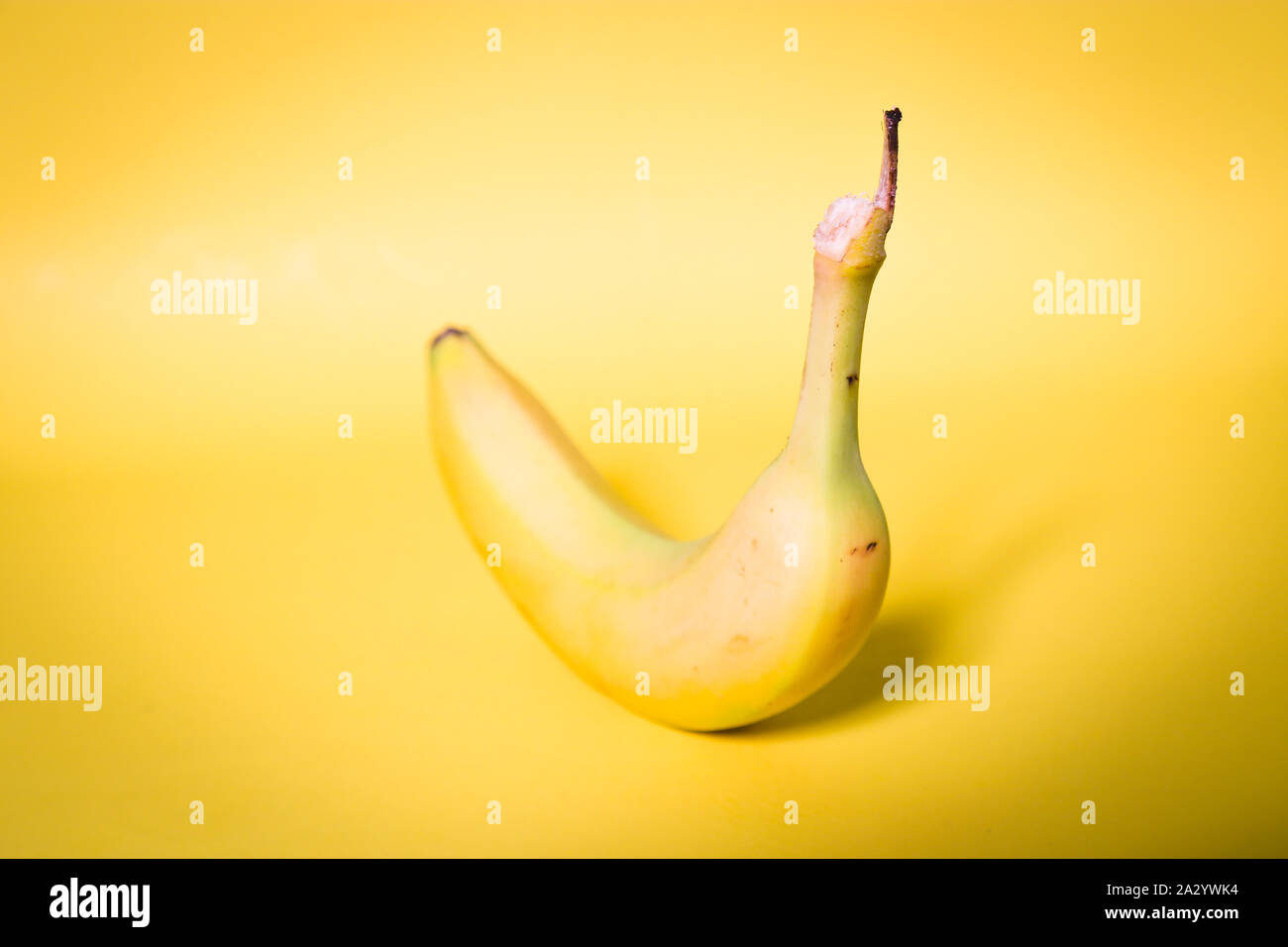 Banana on yellow background, with slight shadow. Single banana Stock ...
