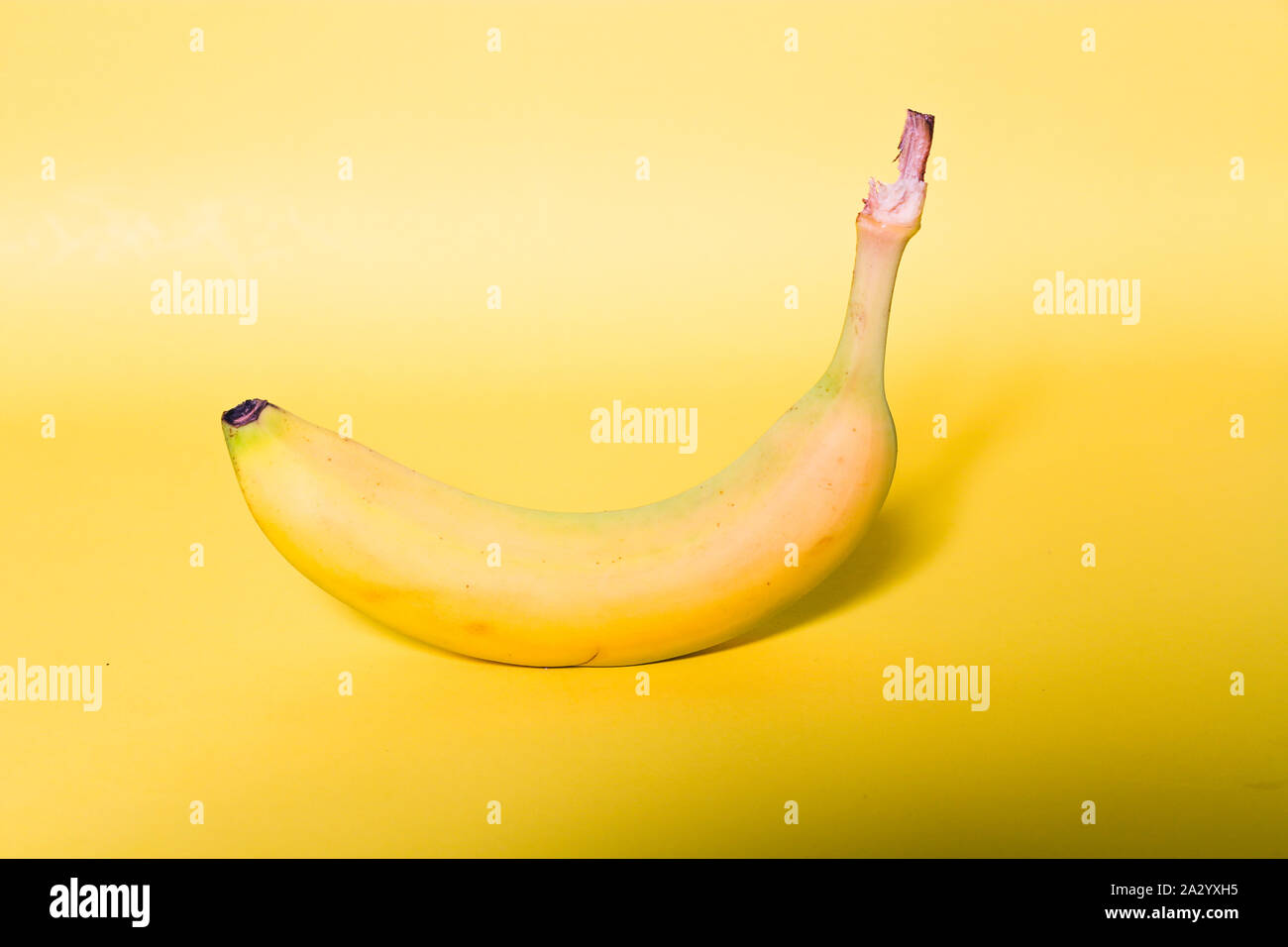 Banana on yellow background, with slight shadow. Single banana Stock ...