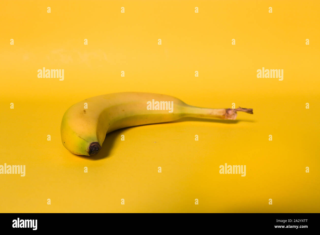 Banana on yellow background, with slight shadow. Single banana Stock ...
