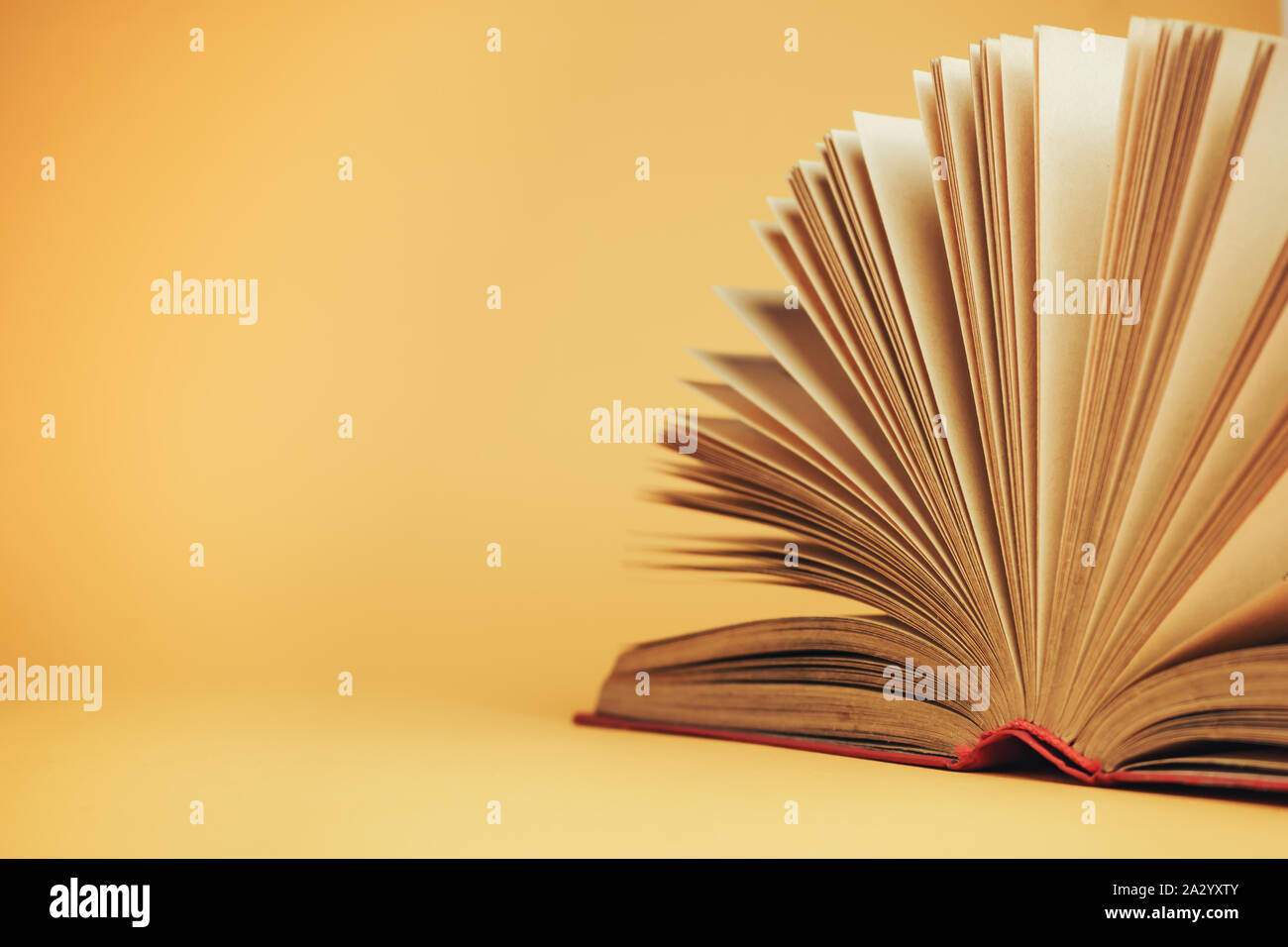 Beautiful open red book on a yellow background Stock Photo - Alamy