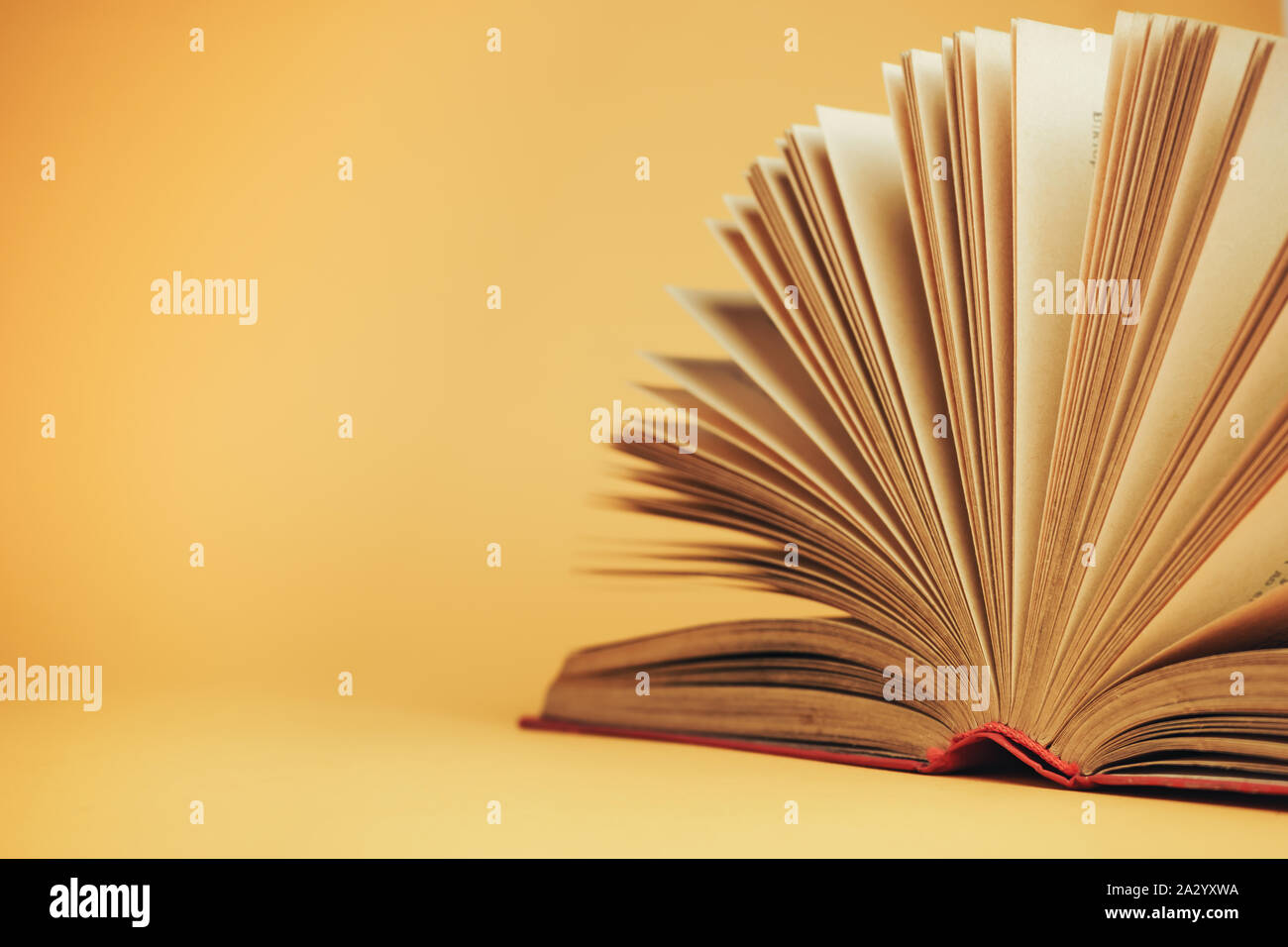 Beautiful open red book on a yellow background Stock Photo - Alamy
