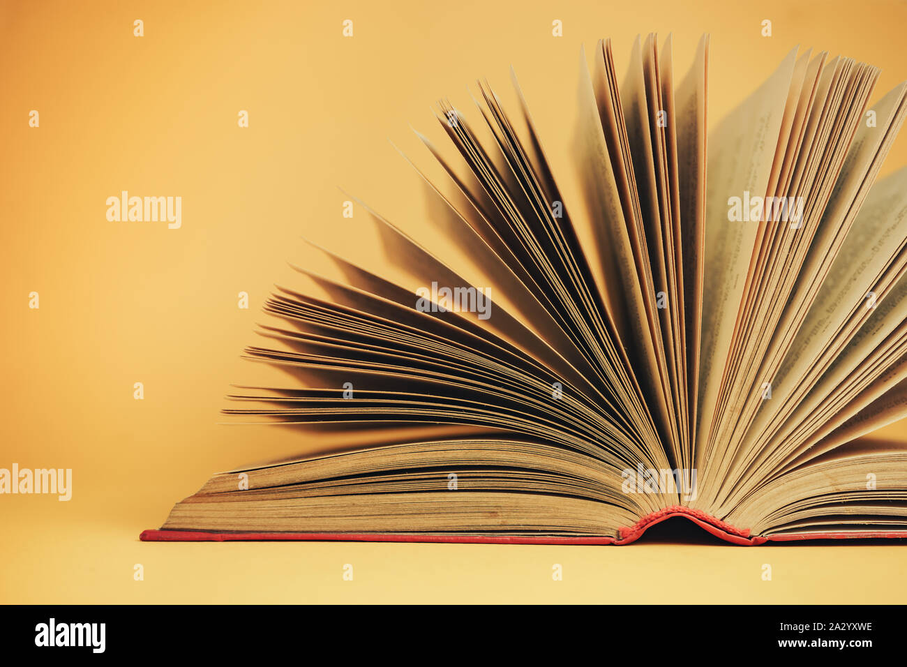 Beautiful open red book on a yellow background Stock Photo - Alamy