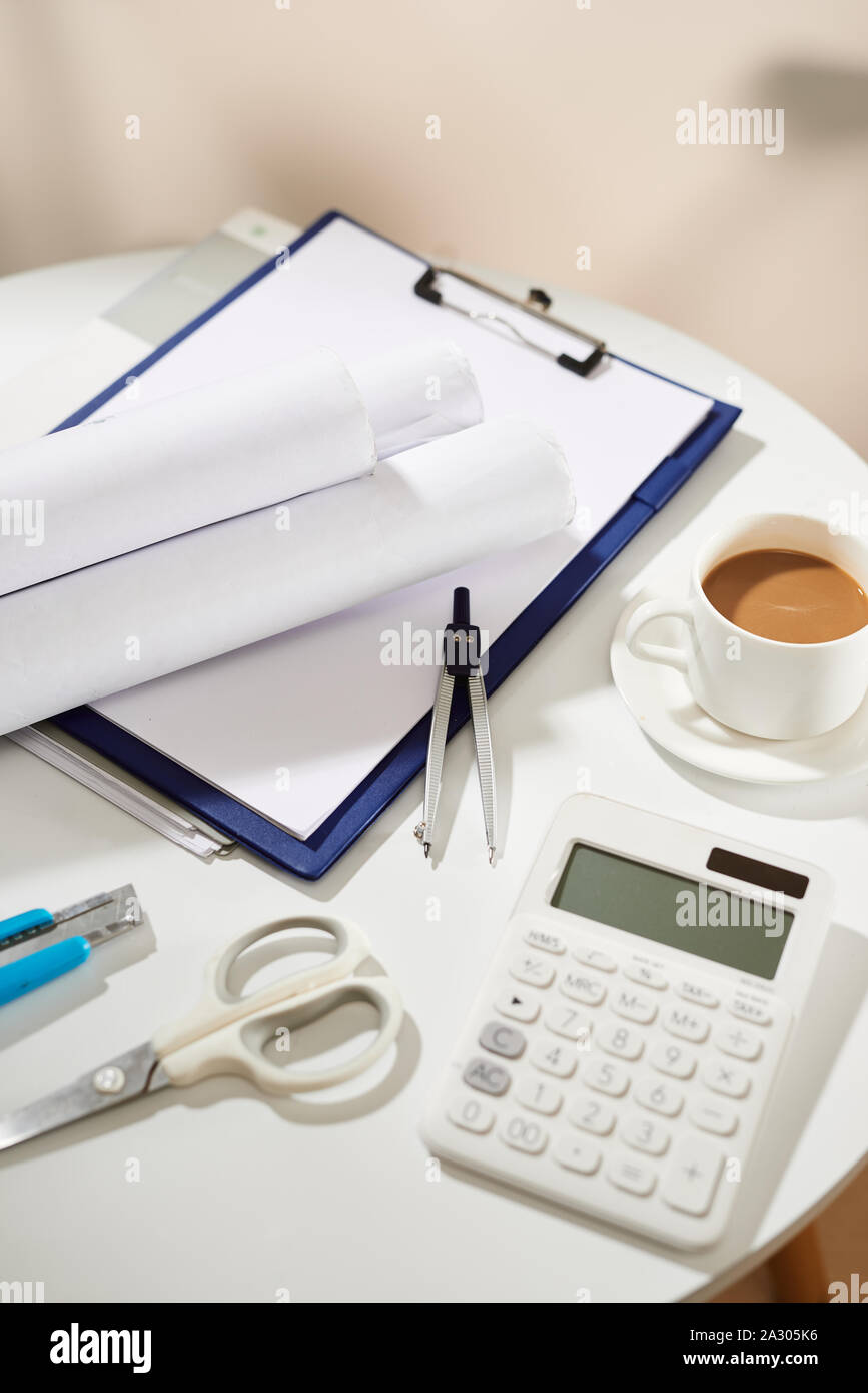 Top view of notebook, empty page, calculator, coffee cup, scissors and ...