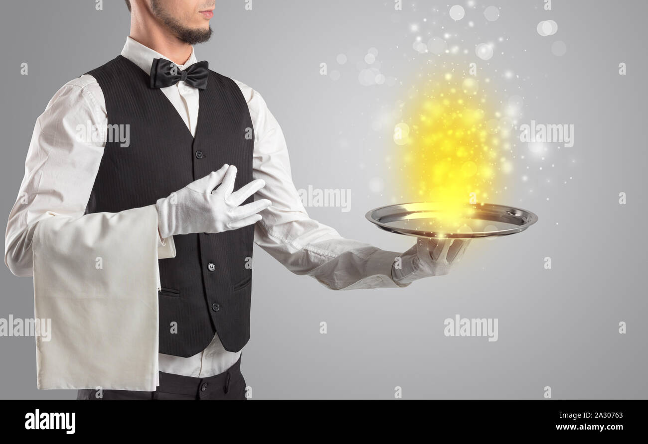 Elegant young waiter serving mysterious light on tray Stock Photo - Alamy