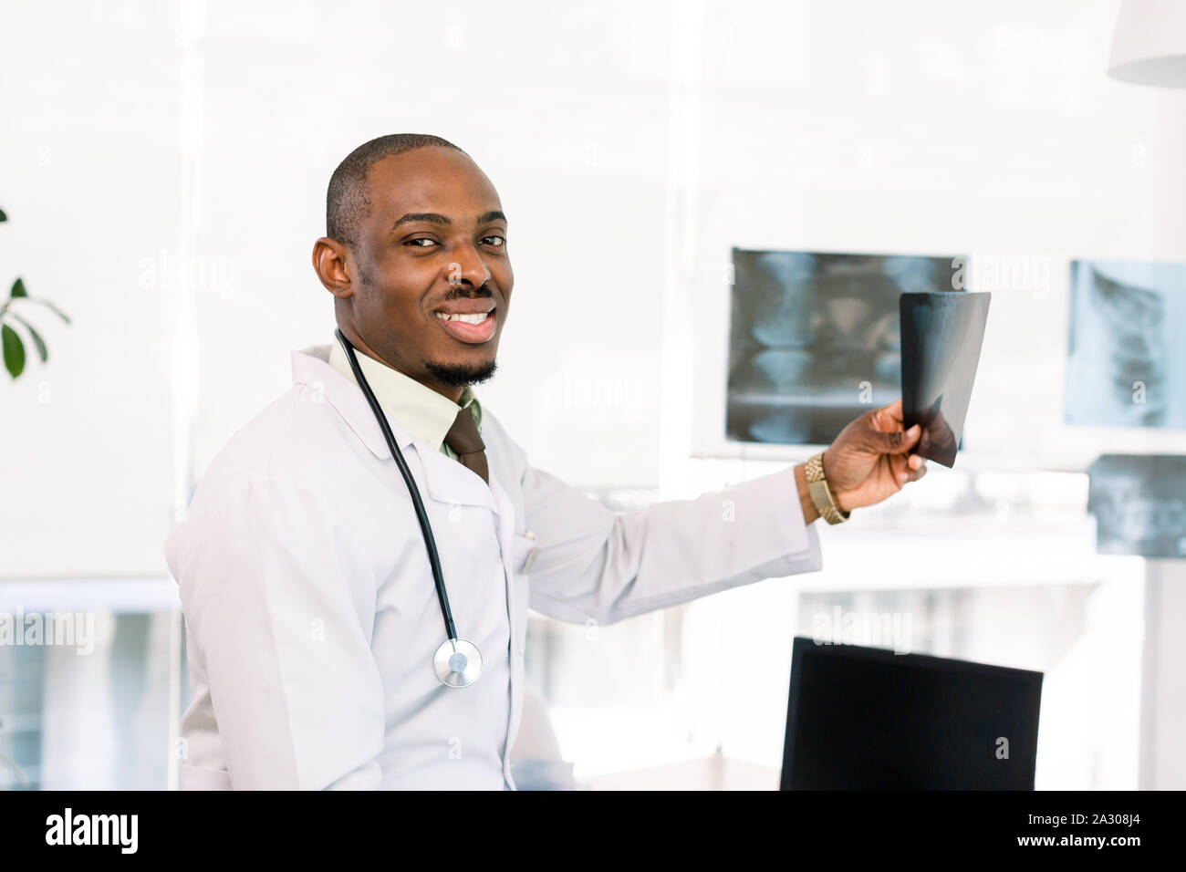 Portrait of a doctor looking at a radiography. African-American black ...