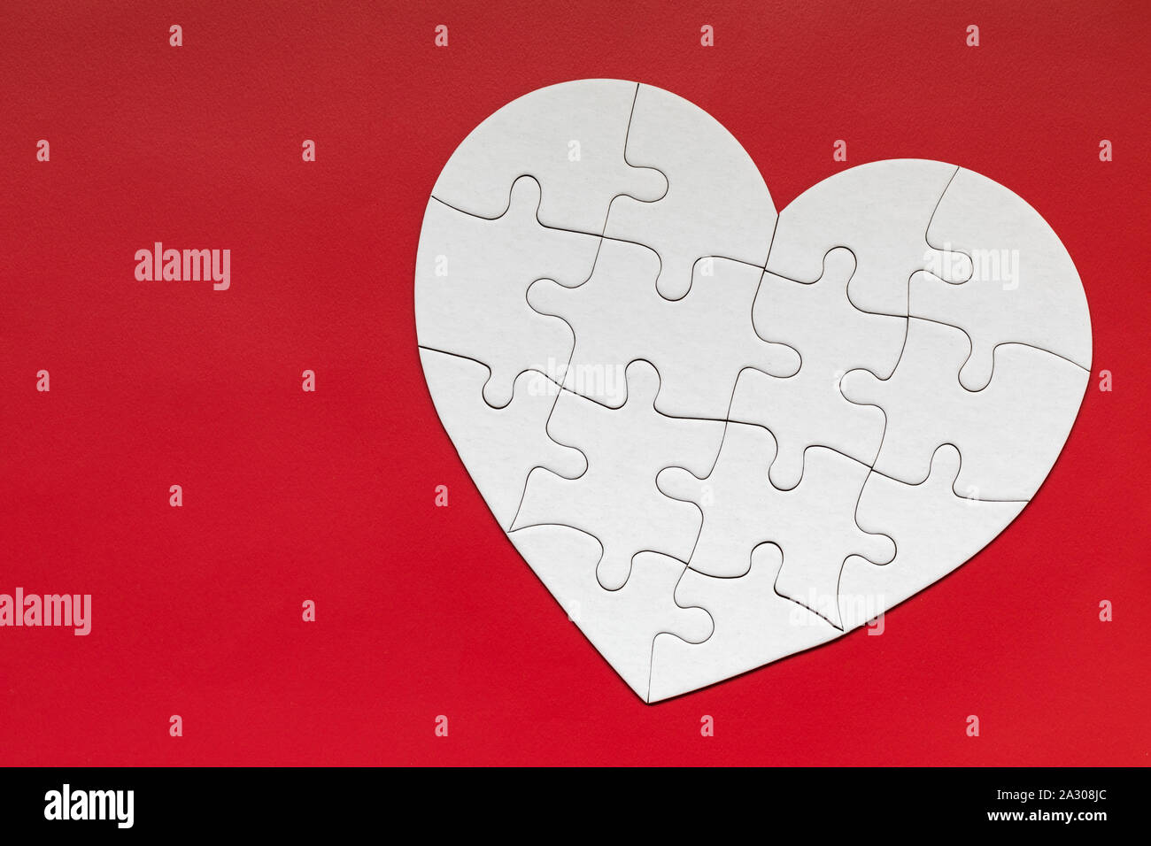 Heart-shaped jigsaw puzzle on color background. Puzzle heart on wooden ...