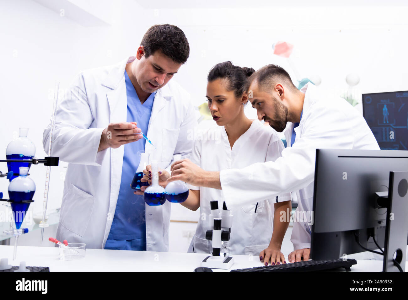 Team of scientist in white coat working together with smoking blue ...