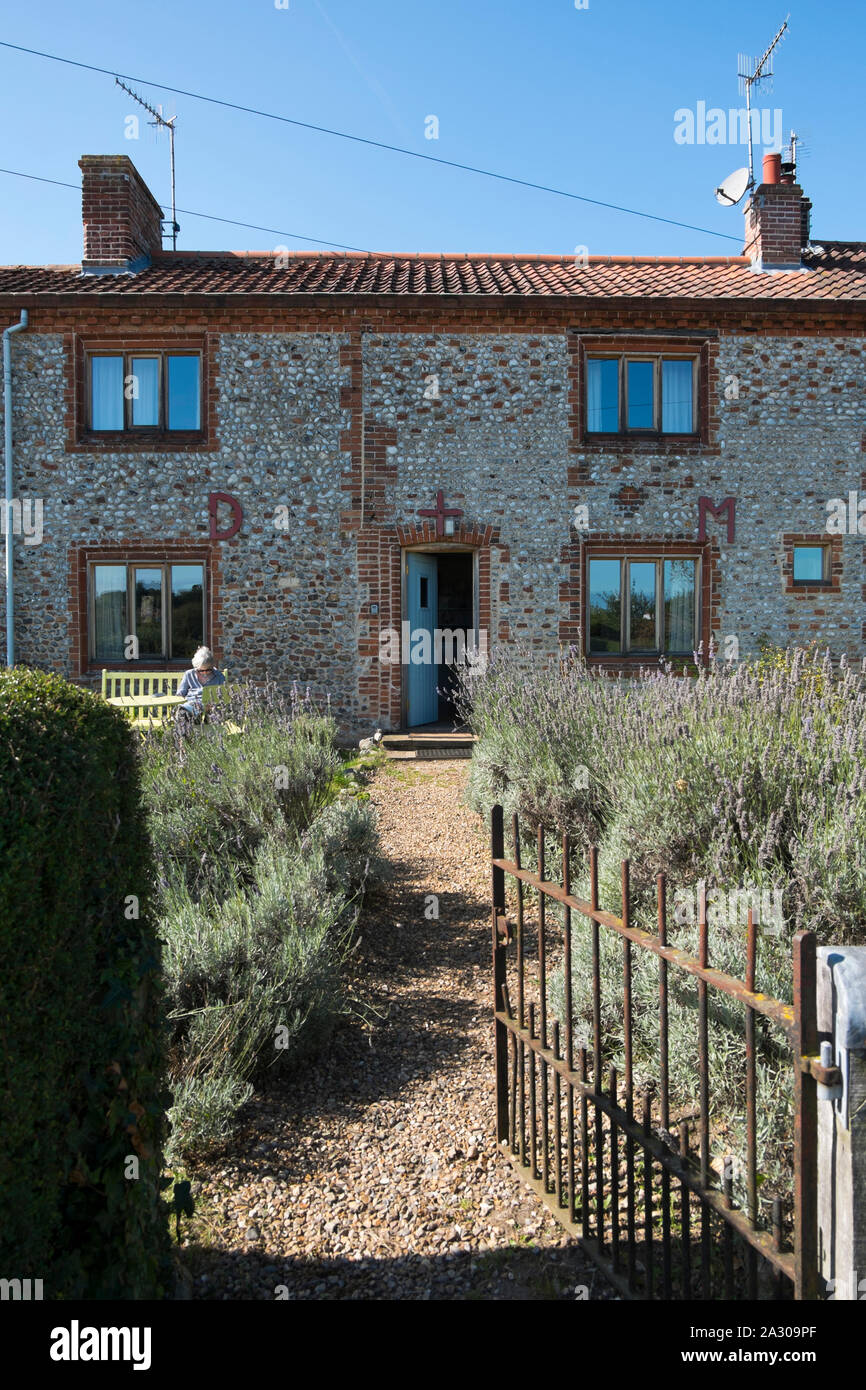 Grey haired grandmother sitting on a bench reading a magazine outside ...