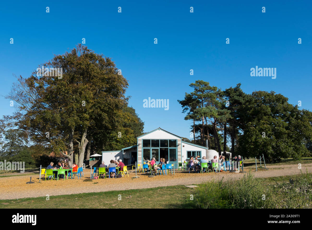 People having lunch and tea on blue, green and yellow chairs and tables ...