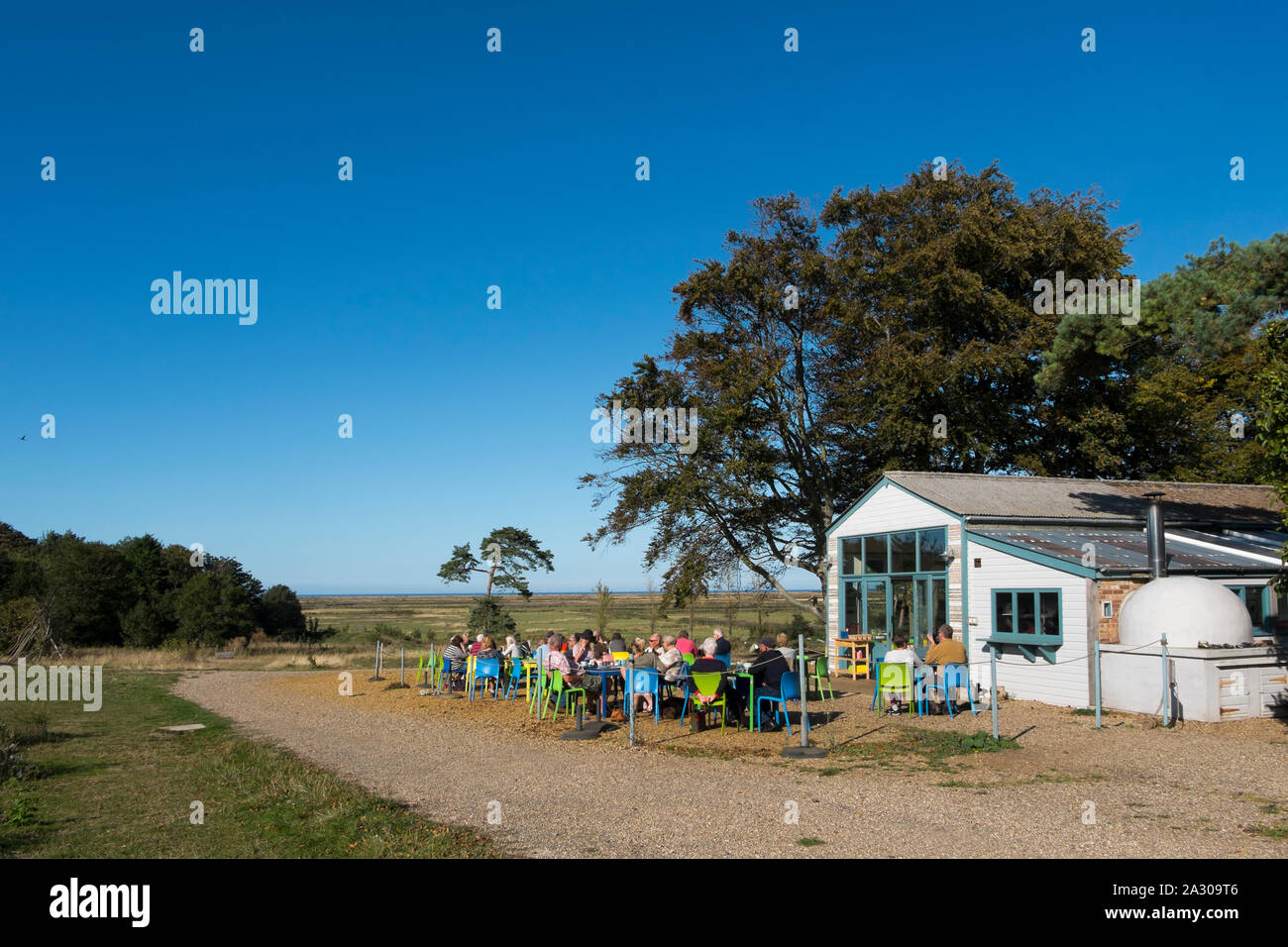 People having lunch and tea on blue, green and yellow chairs and tables ...