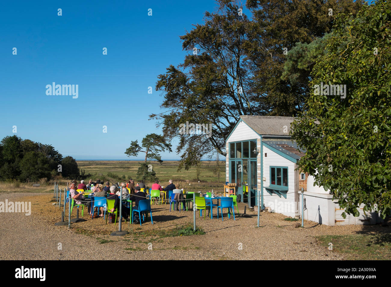 People having lunch and tea on blue, green and yellow chairs and tables ...