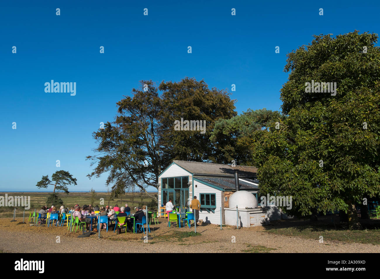 People having lunch and tea on blue, green and yellow chairs and tables ...
