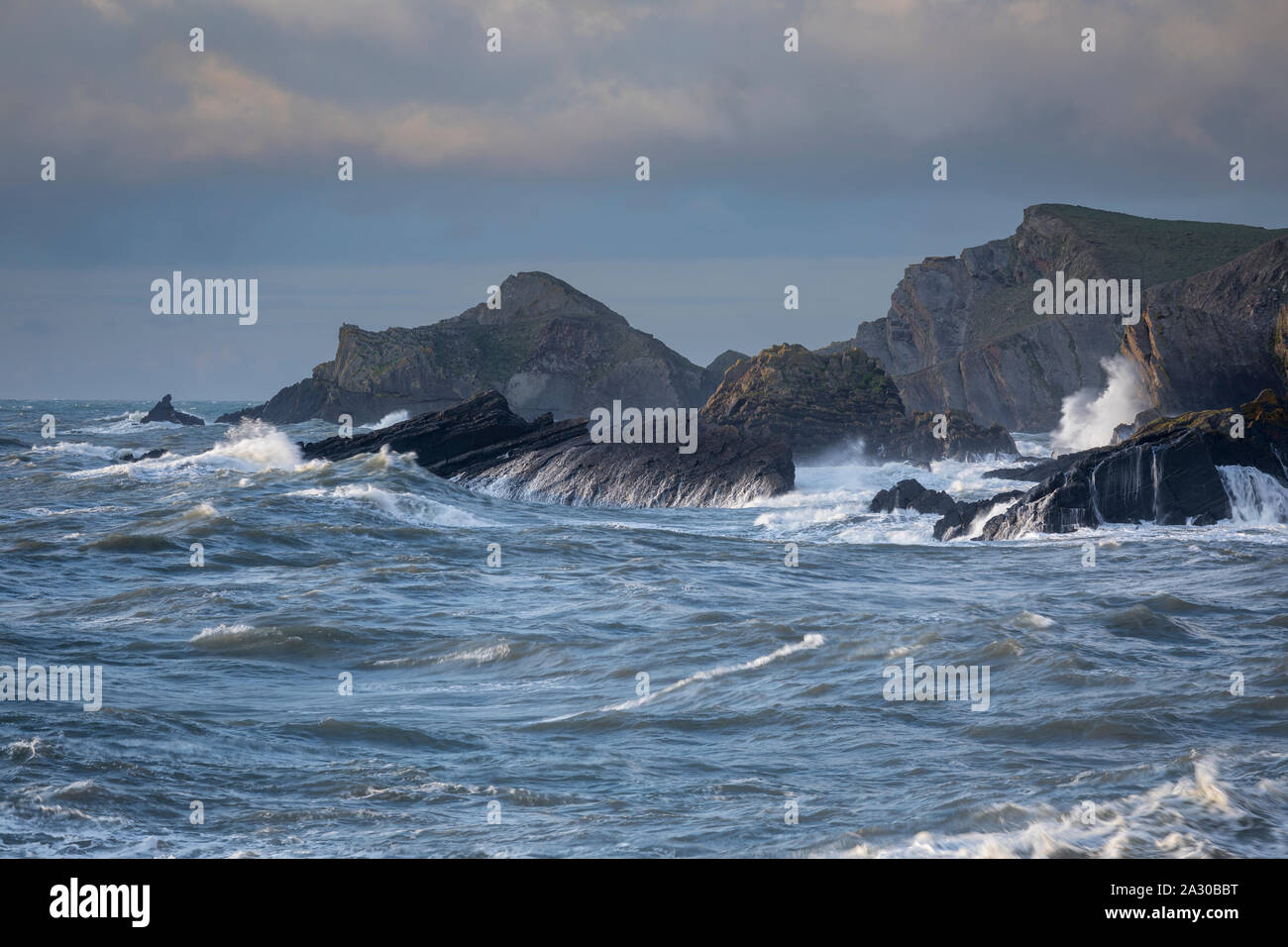 Giant waves crash over rocks on the rugged coastline of hartland in ...