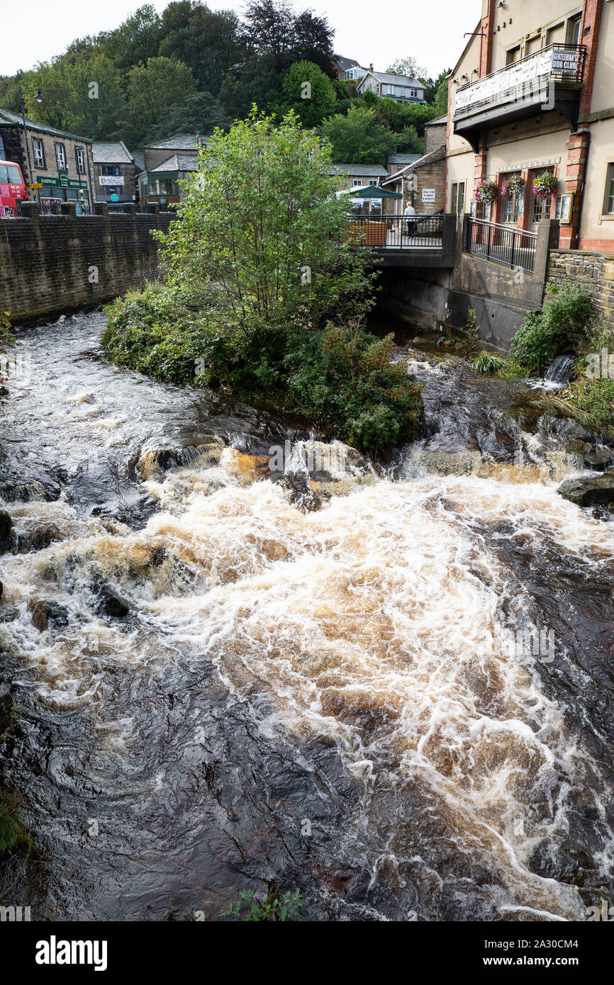 The River Holme in full spate passing through the small town of ...