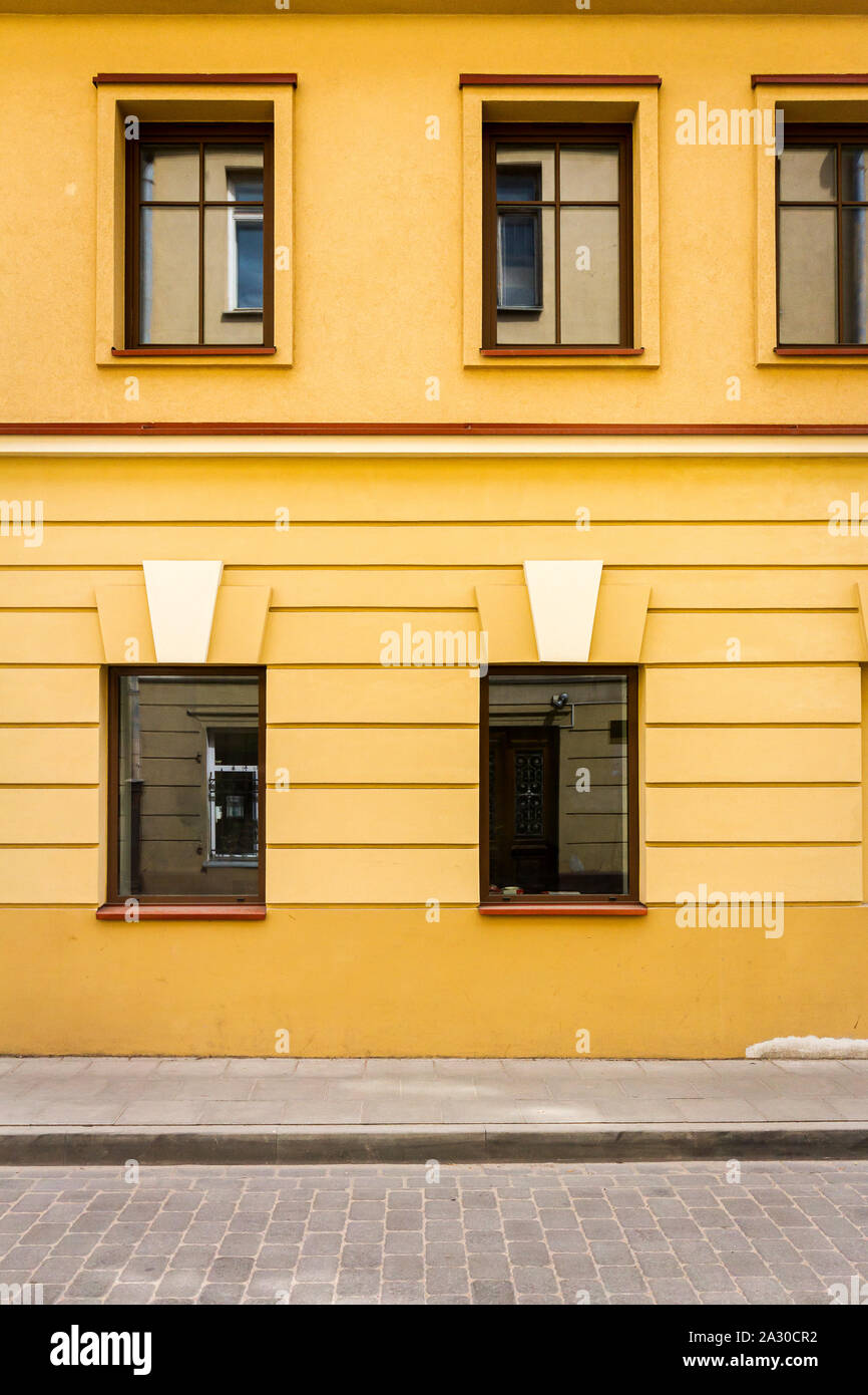 Modern yellow street wall with some windows Stock Photo - Alamy