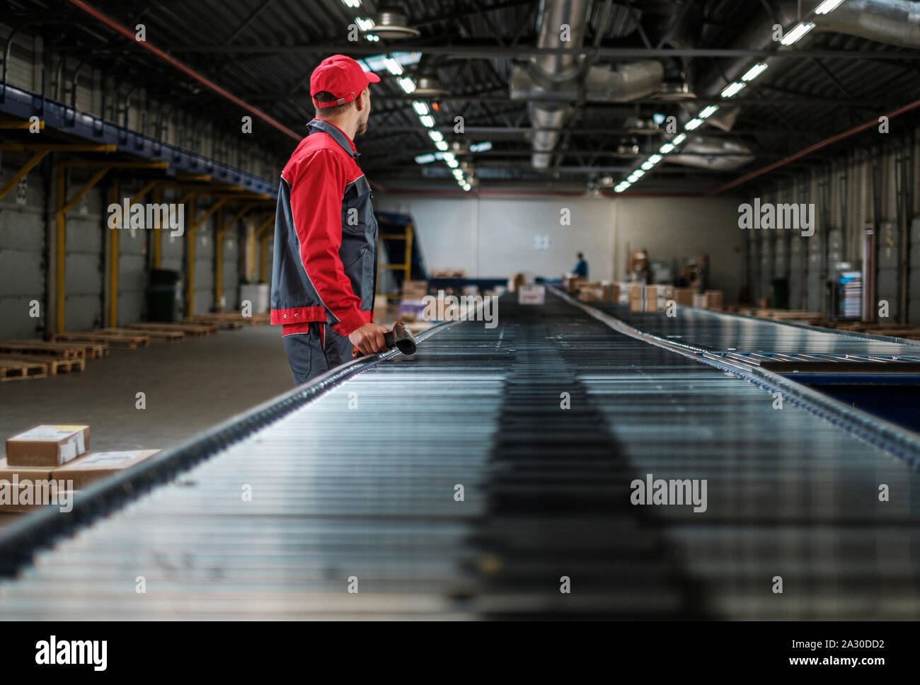 Warehouse worker working on a conveyor line Stock Photo - Alamy
