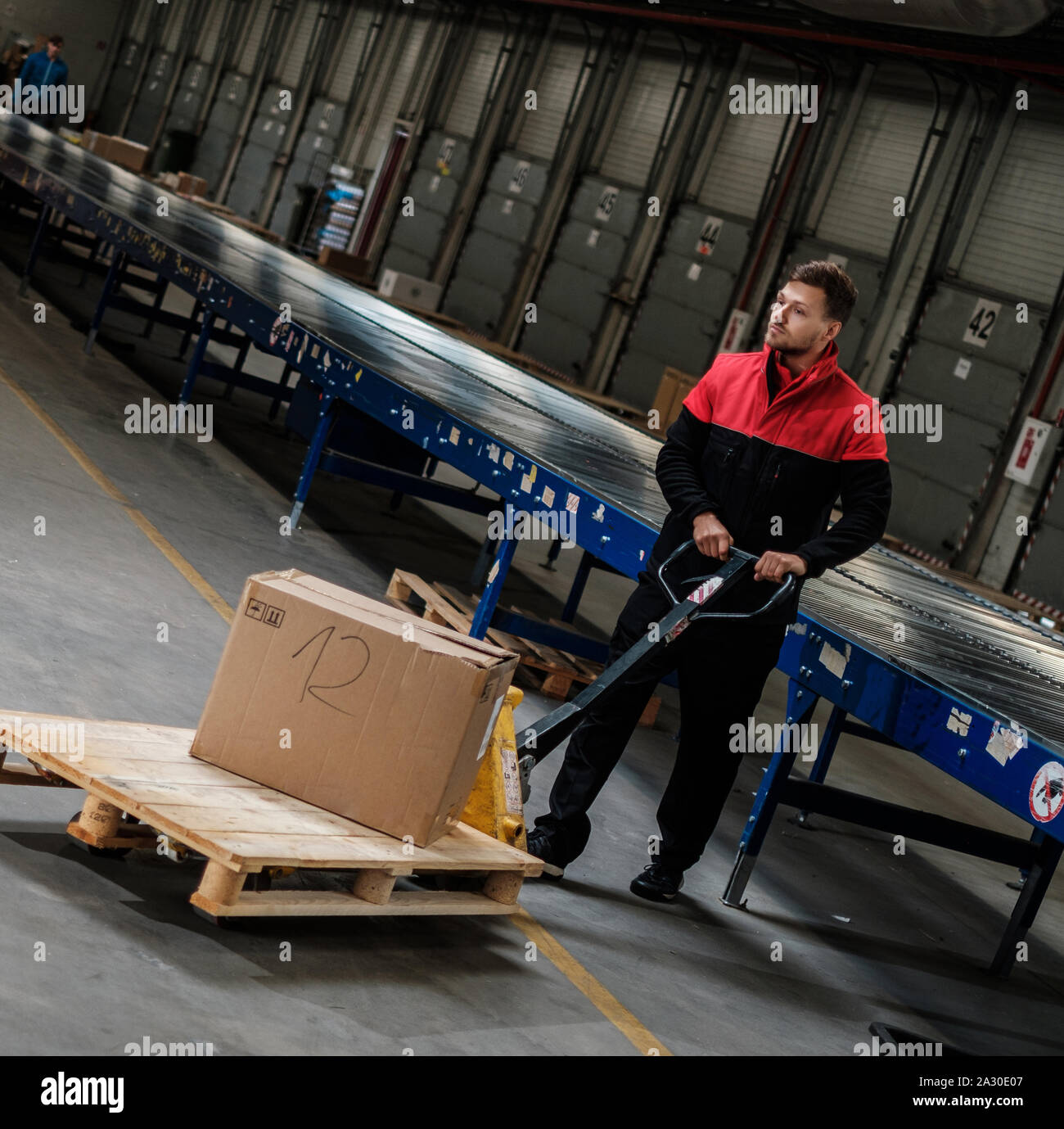 Warehouse worker with a pallet rack Stock Photo - Alamy