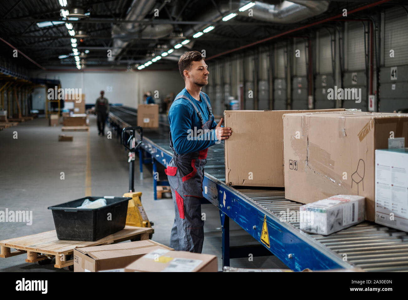 Warehouse worker working on a conveyor line Stock Photo - Alamy