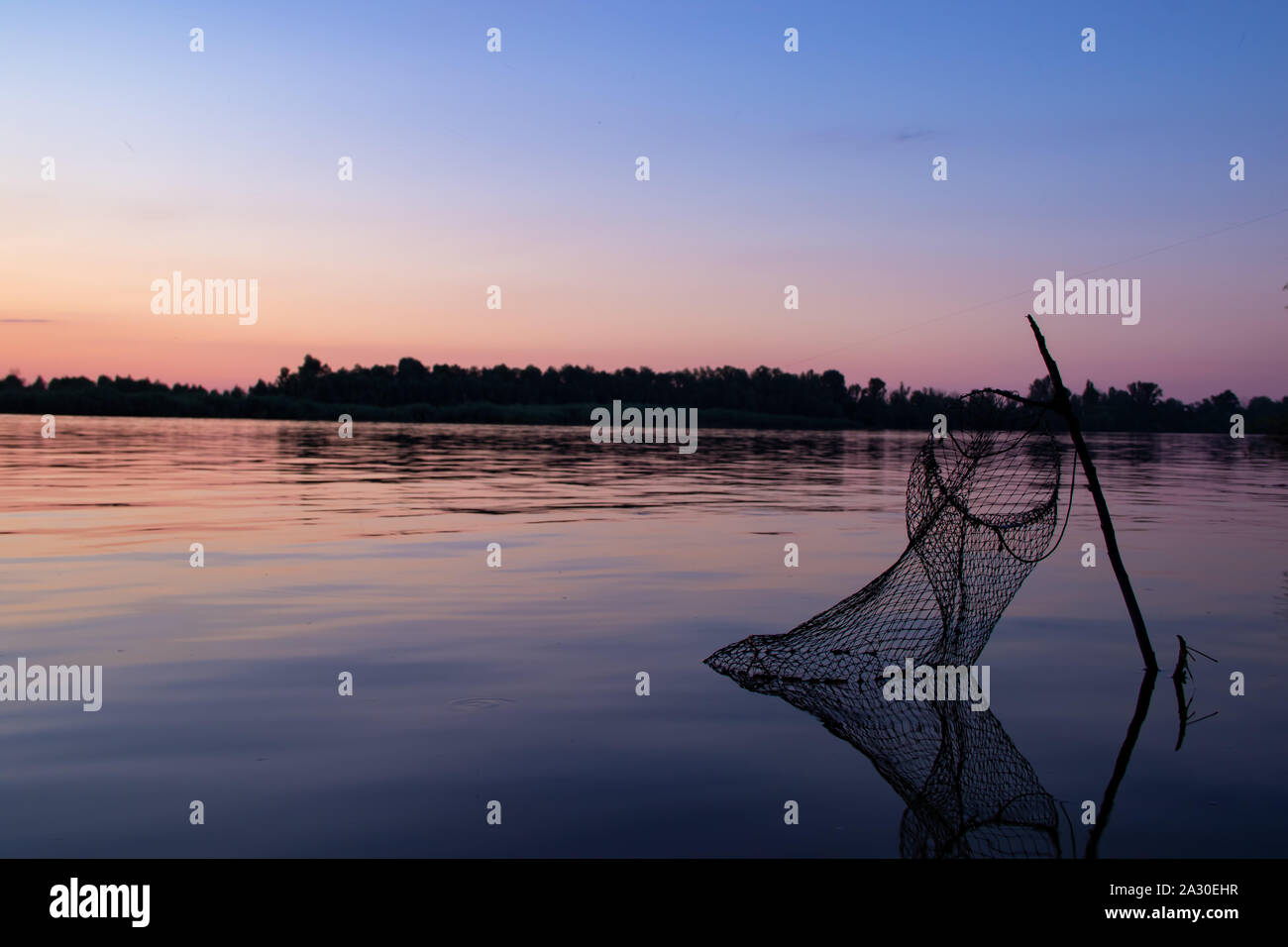 Fishing on the river bank is a grid for fish in the water on the ...