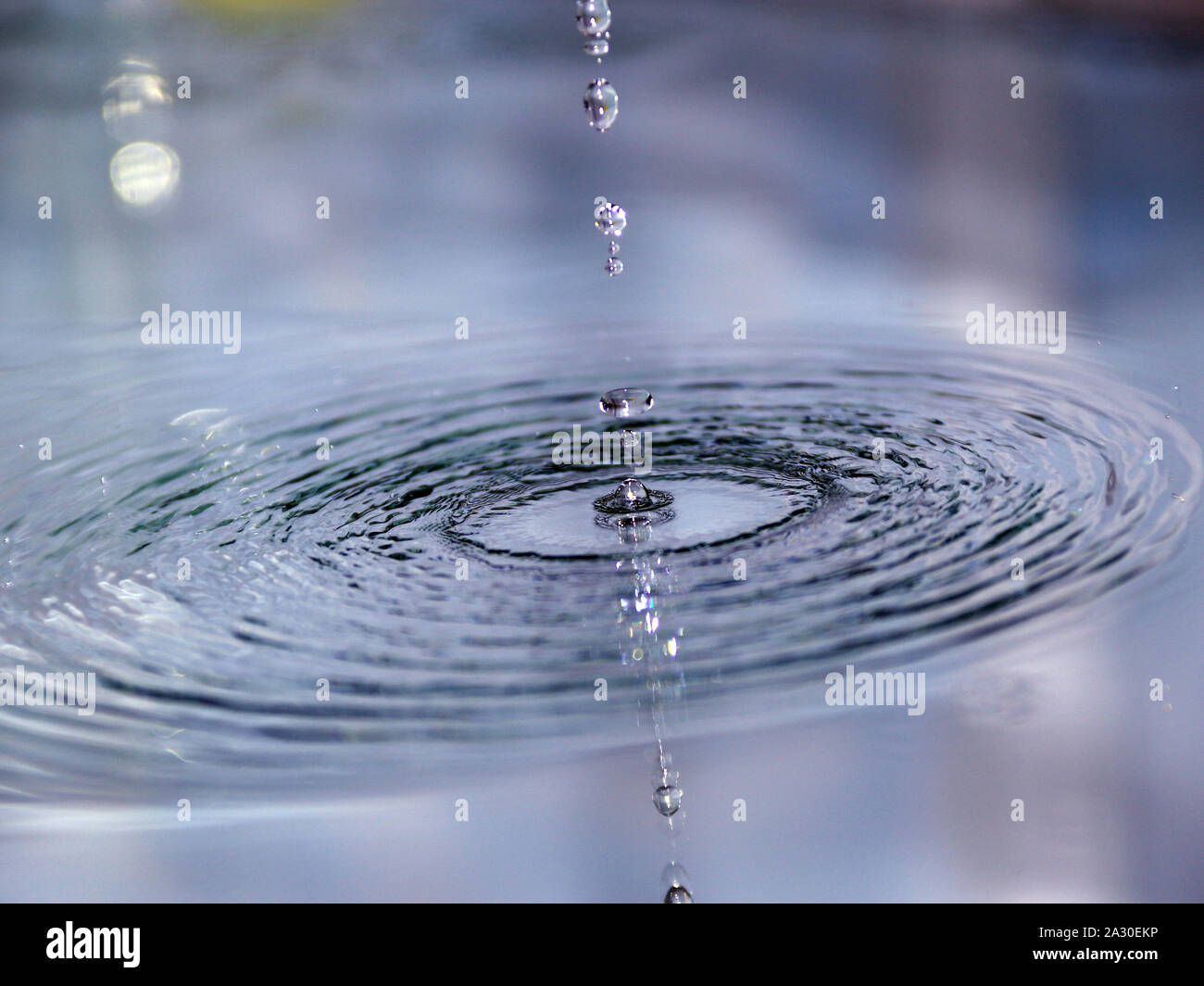 Drops of water drip on the mirror surface and create waves and splashes ...
