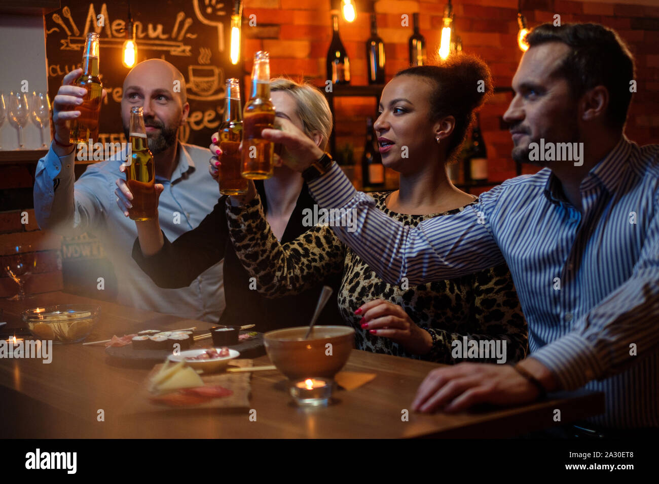 Group of friends watching tv in a cafe behind bar counter Stock Photo ...