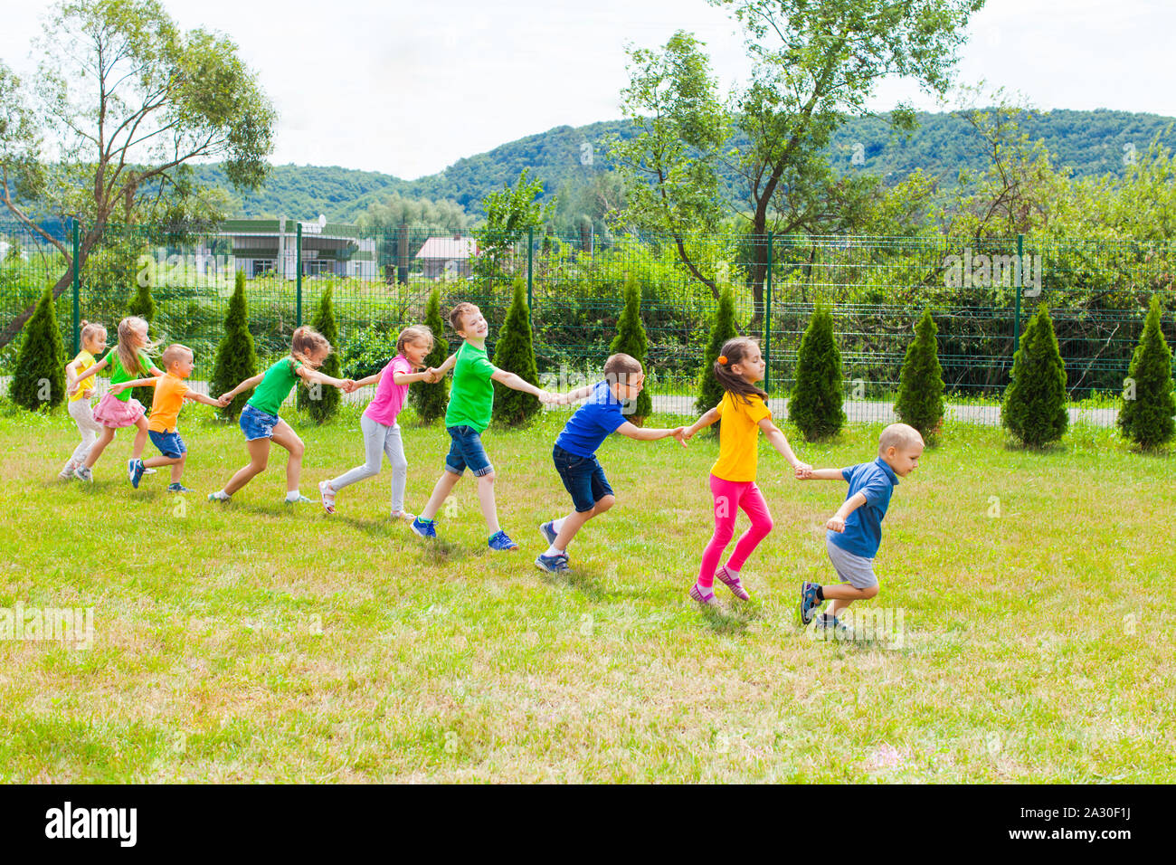Kids train on the lawn. Children follow to each others and run together ...