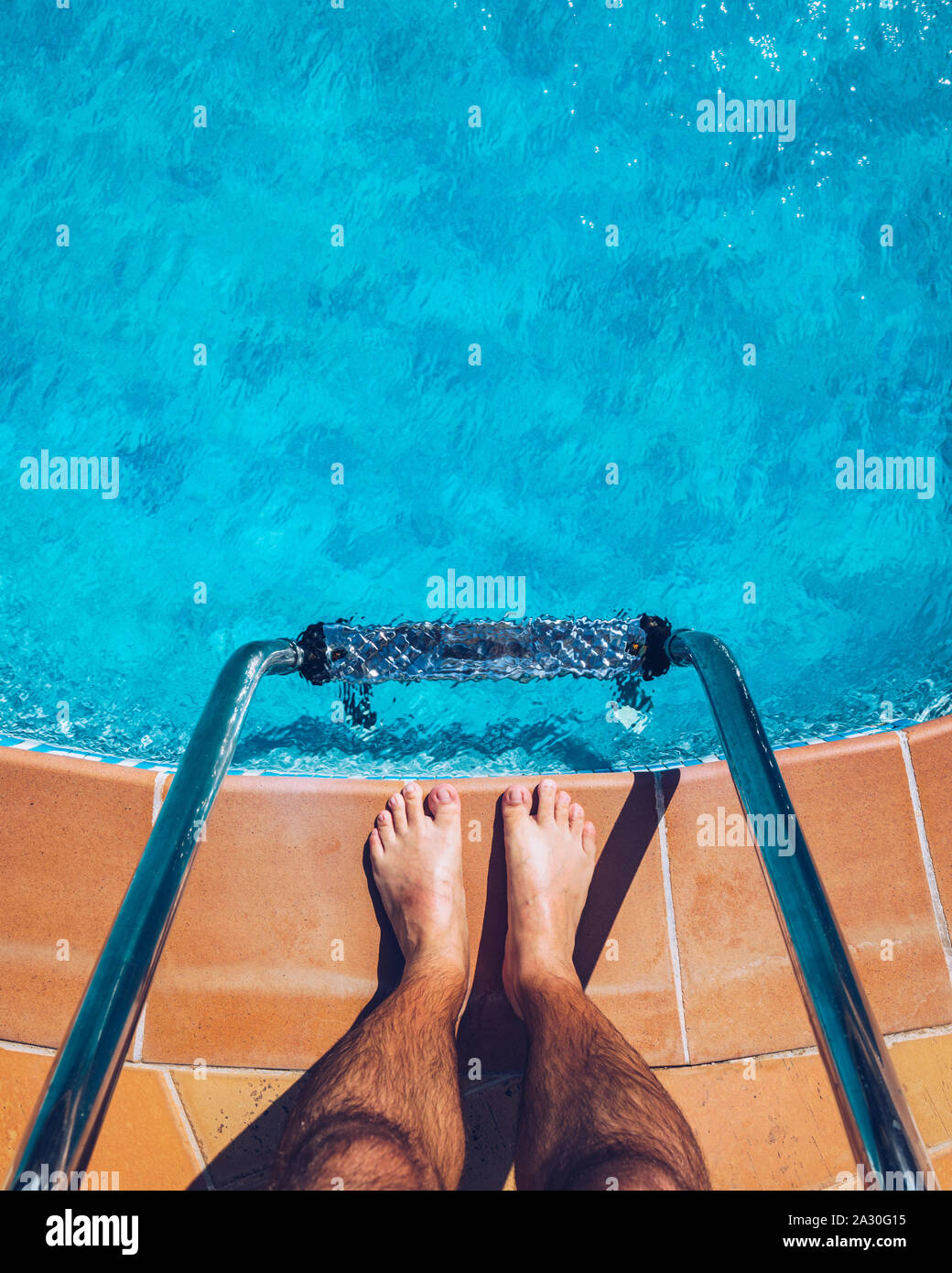 Relaxing at the swimming pool. Man relaxing next to swimming pool. Man ...