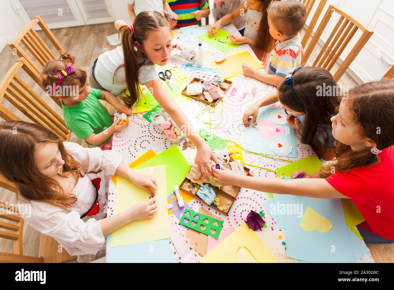 Children make handycrafts, little boys and girls sit around the table ...