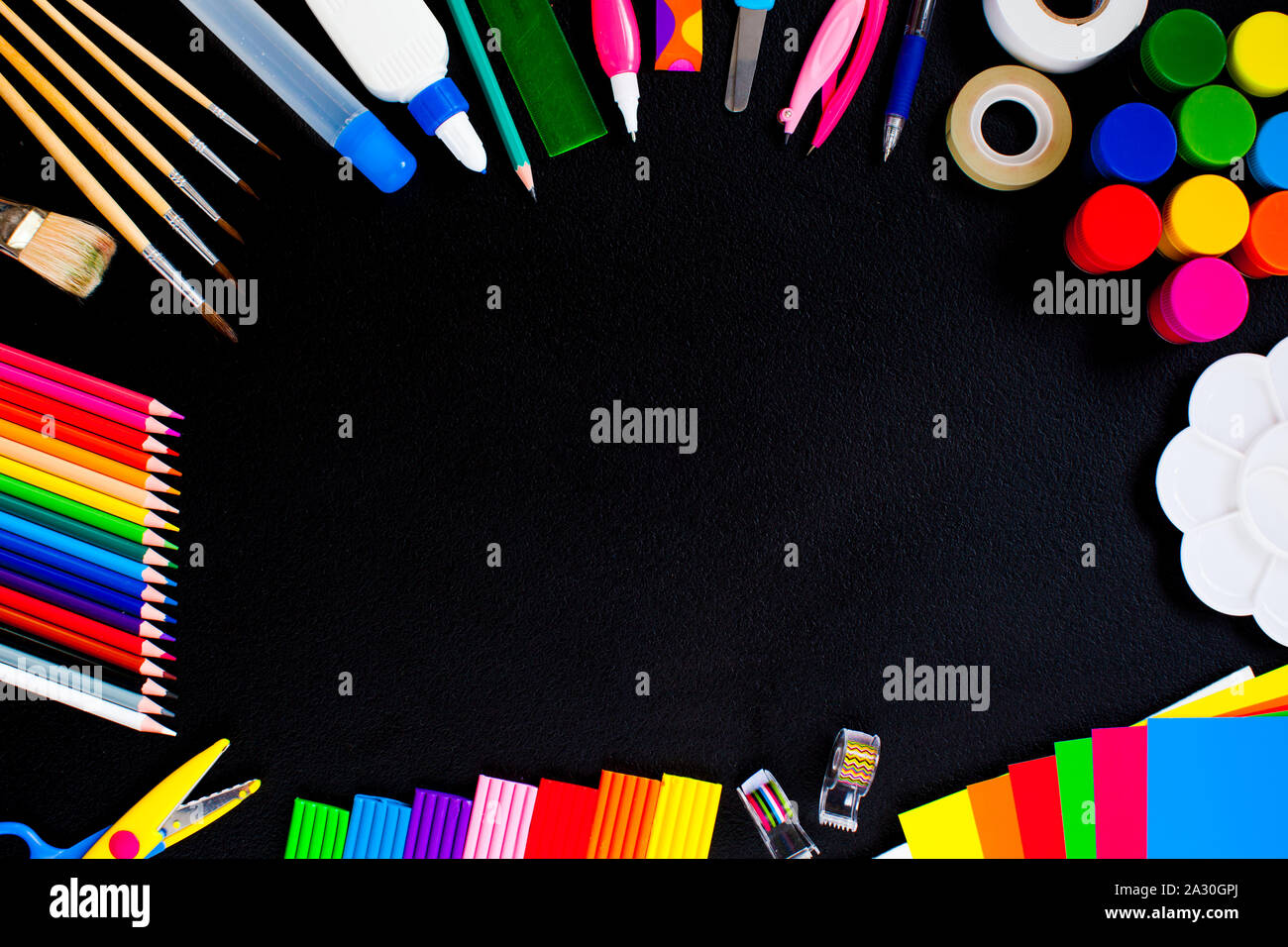 Back to school concept on black table. Top view of frame with colourful ...