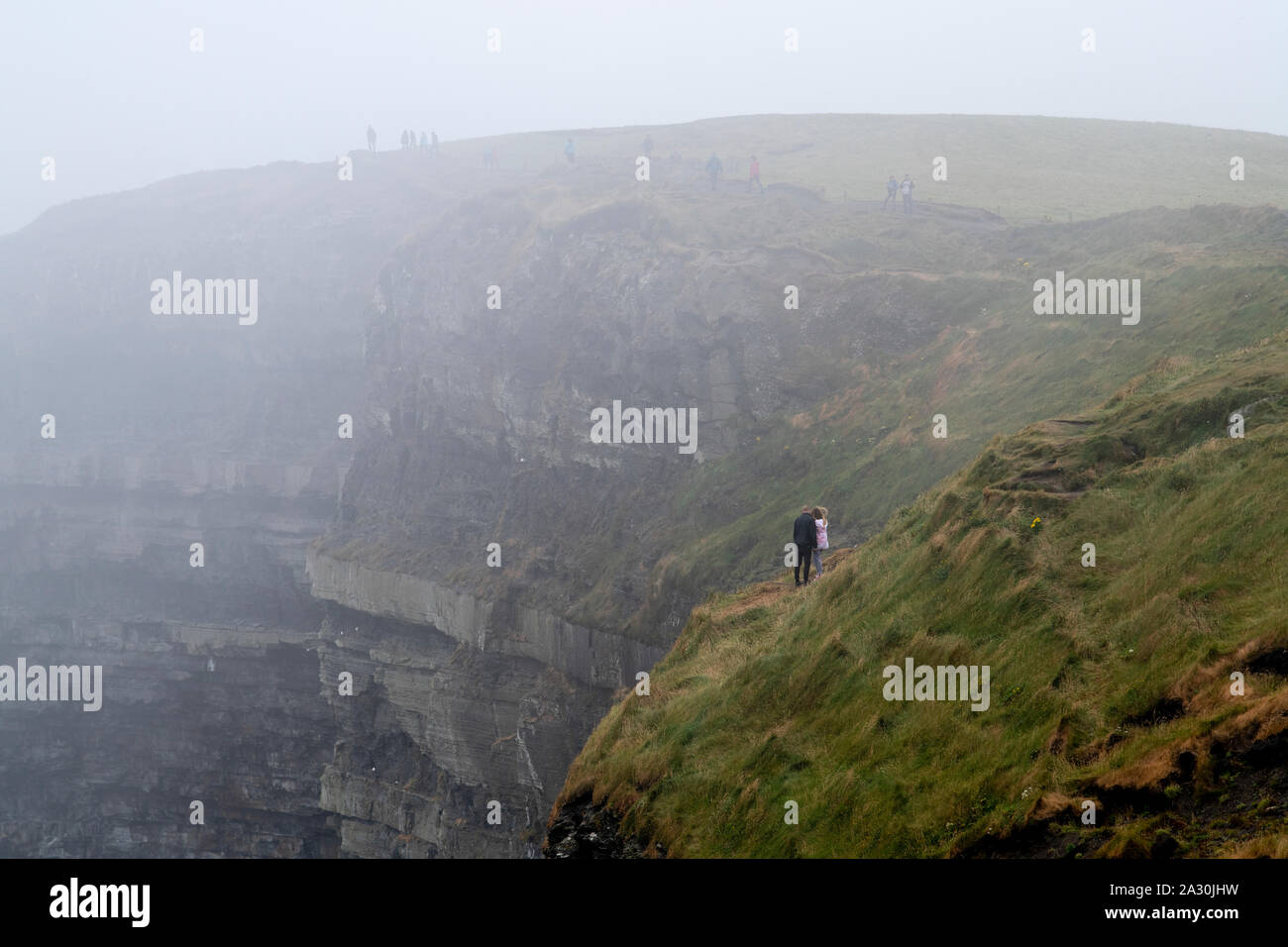 Tourists on cliff, Cliffs of Moher, Lahinch, County Clare, Ireland ...