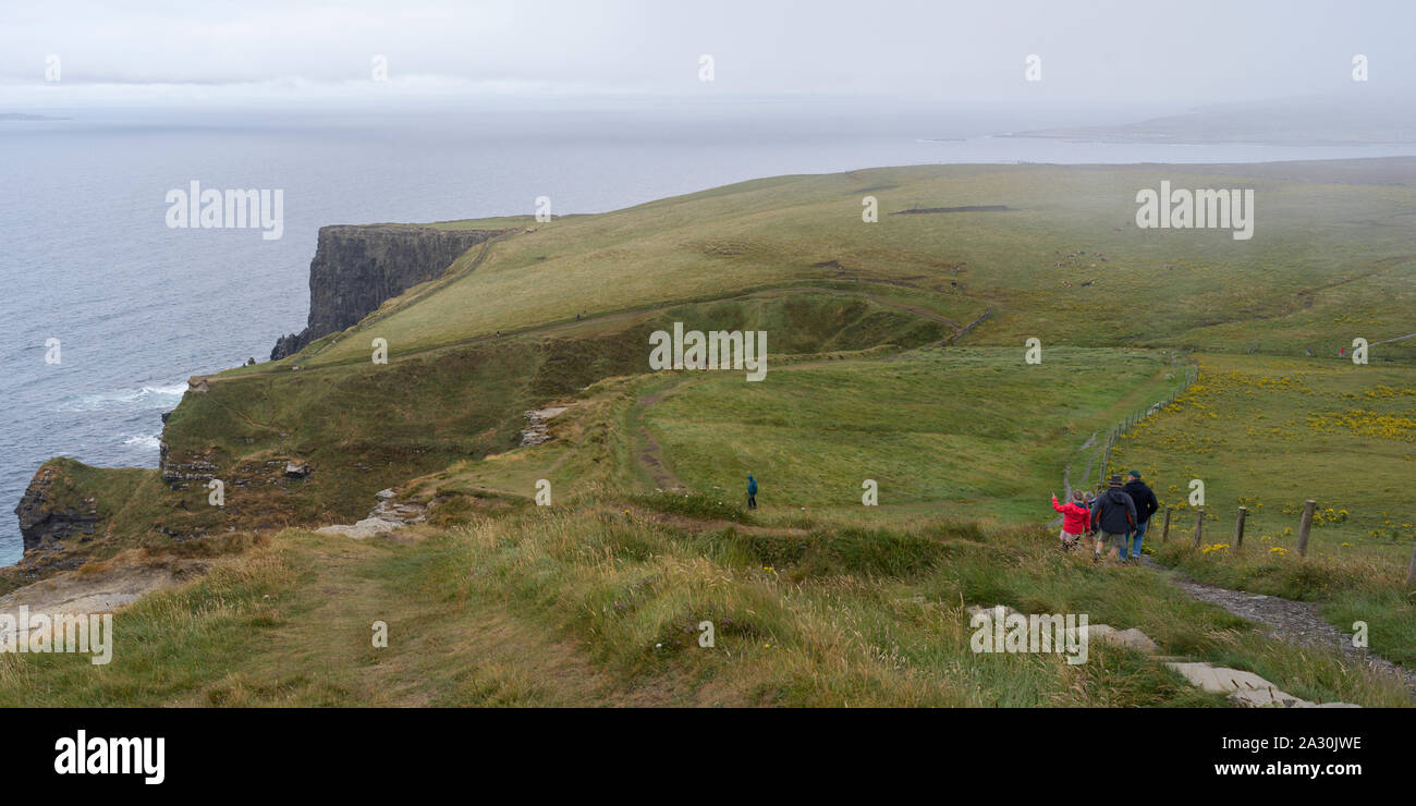 Tourists on cliff, Cliffs of Moher, Lahinch, County Clare, Ireland ...