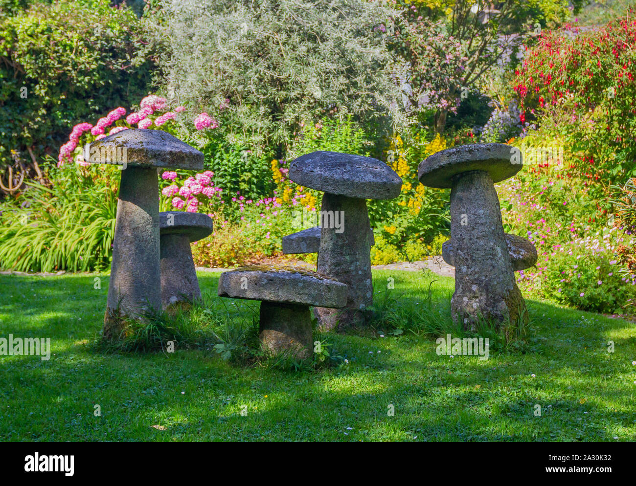 Seven stone staddle stones, ornamental toadstools, in dappled sunlight ...