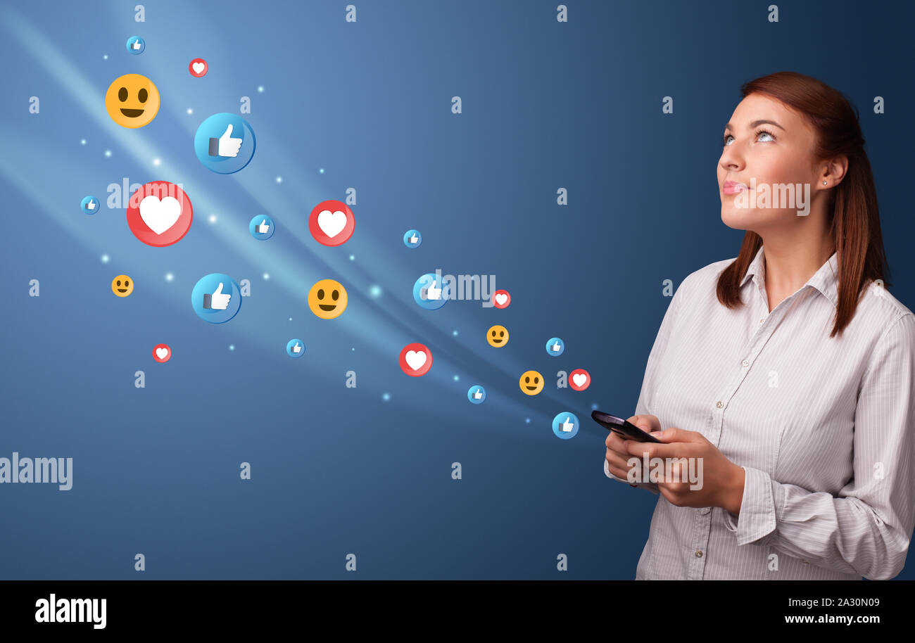 Young person using smartphone with flying social media icons around ...