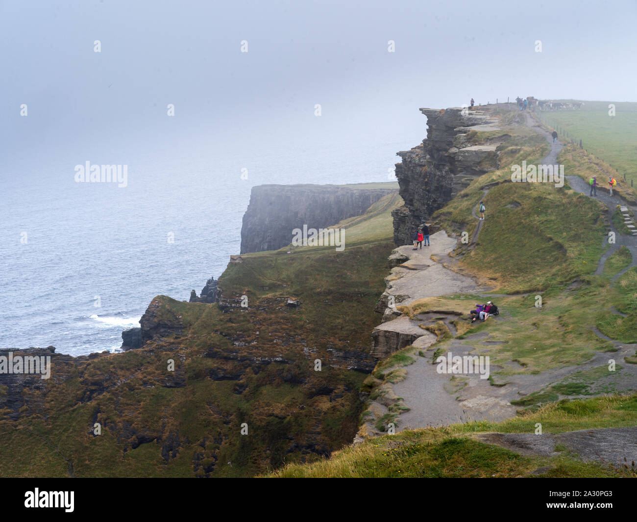 Tourists on cliff, Cliffs of Moher, Lahinch, County Clare, Ireland ...