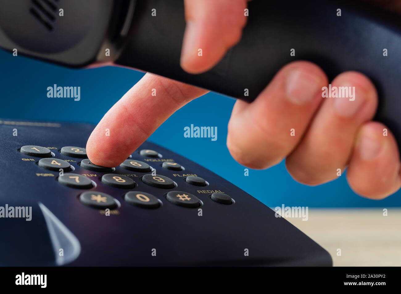 Closeup view of male hand holding telephone receiver dialing phone ...