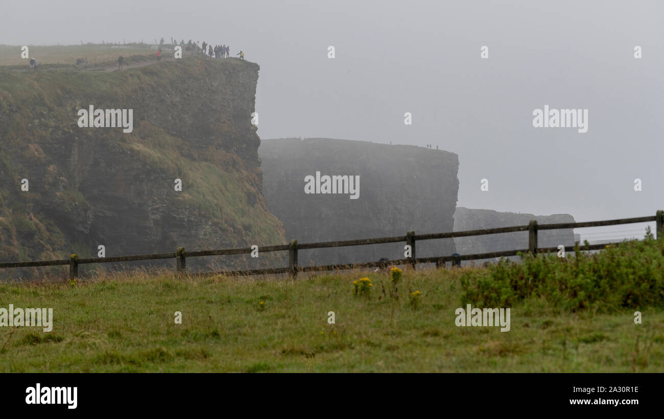 Tourists on cliff, Cliffs of Moher, Lahinch, County Clare, Ireland ...
