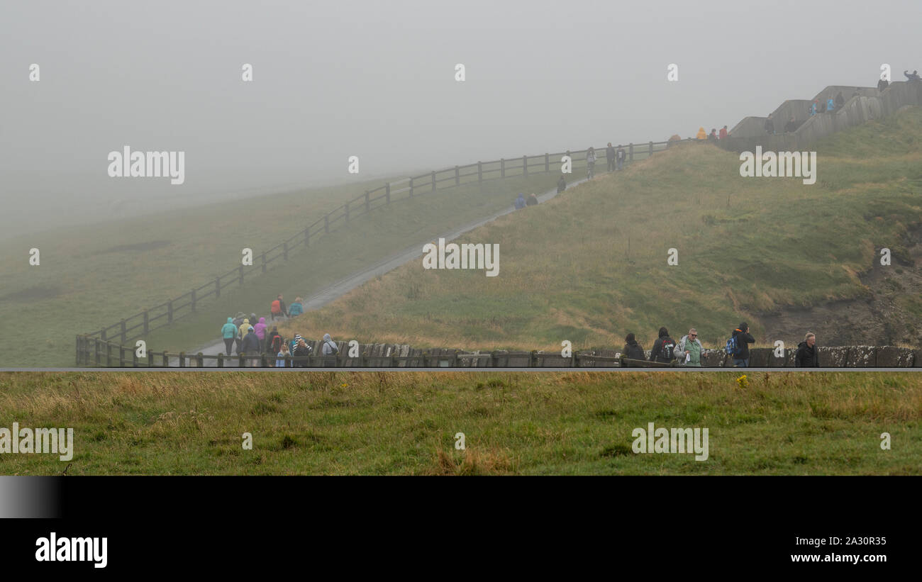 Tourists on cliff, Cliffs of Moher, Lahinch, County Clare, Ireland ...