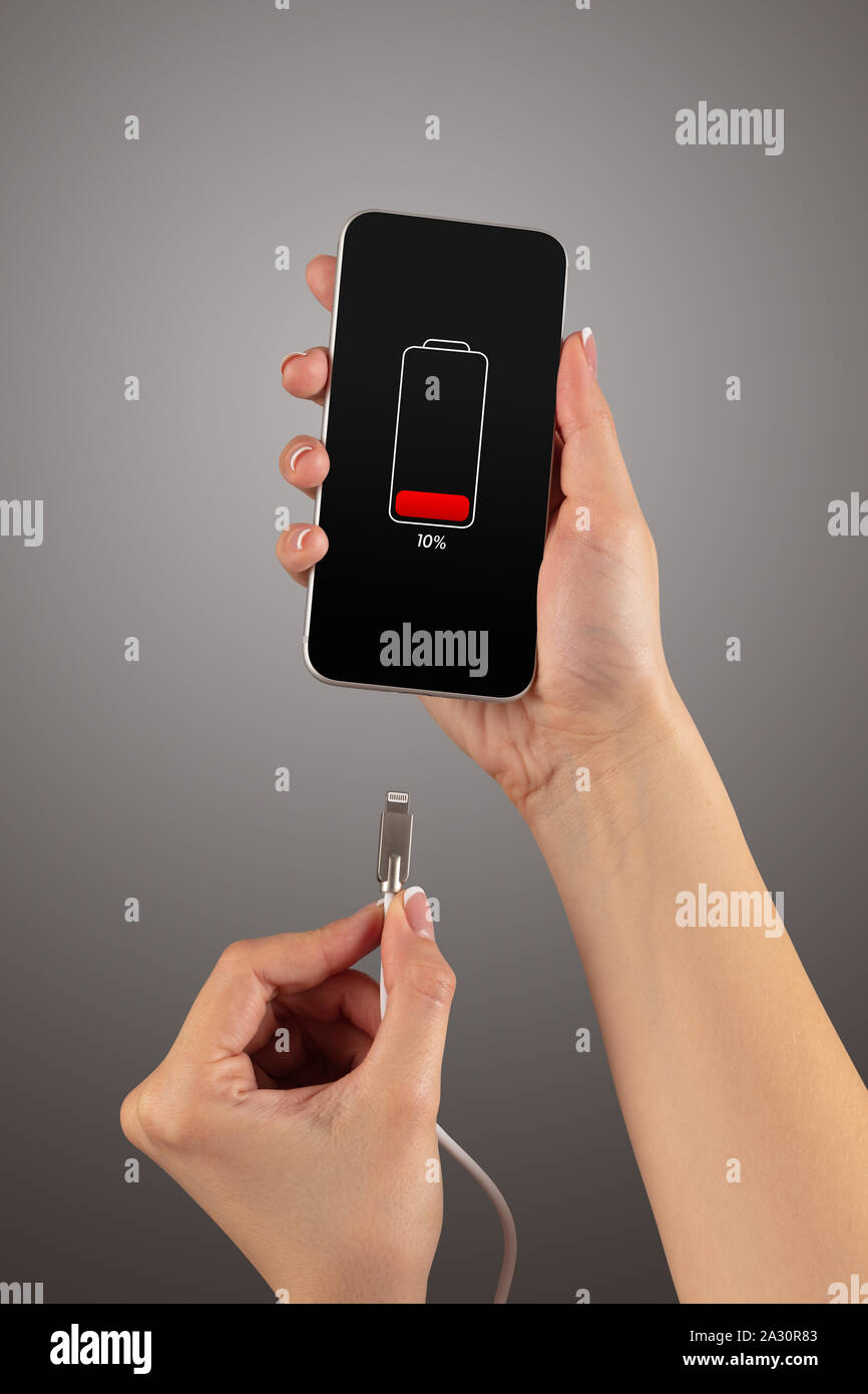 Elegant hand charging cellphone with low battery Stock Photo - Alamy