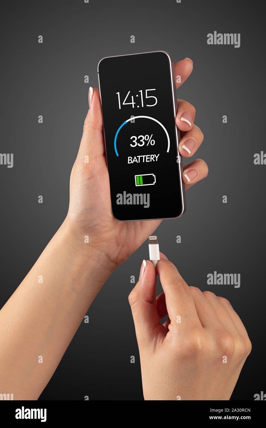 Elegant hand charging cellphone with low battery Stock Photo - Alamy