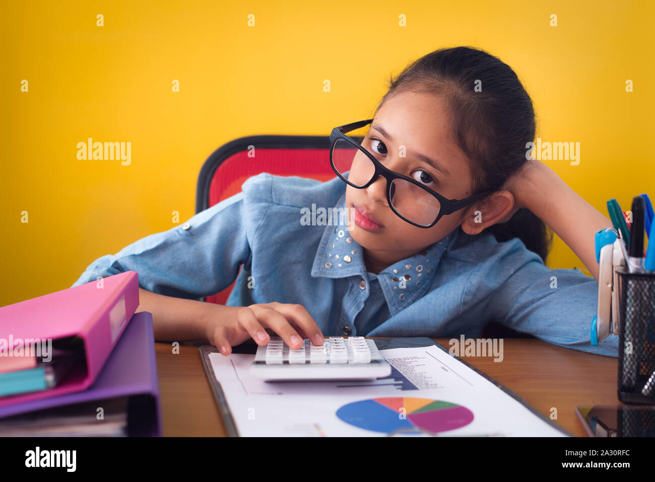 Cute girl wearing glasses is boring with hard work on the desk isolated ...