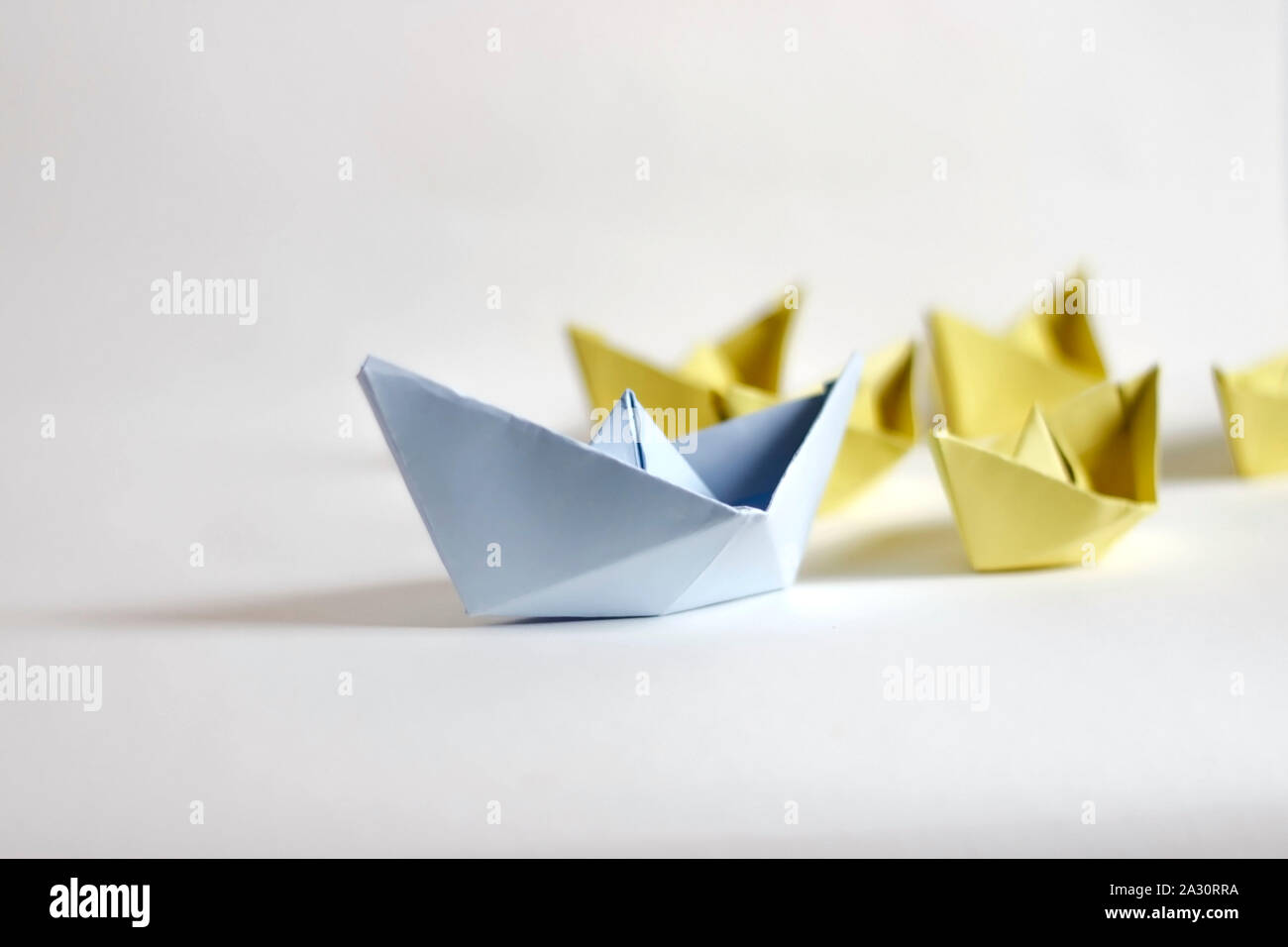 Leadership concept. Paper boats on a white background. Leader before ...