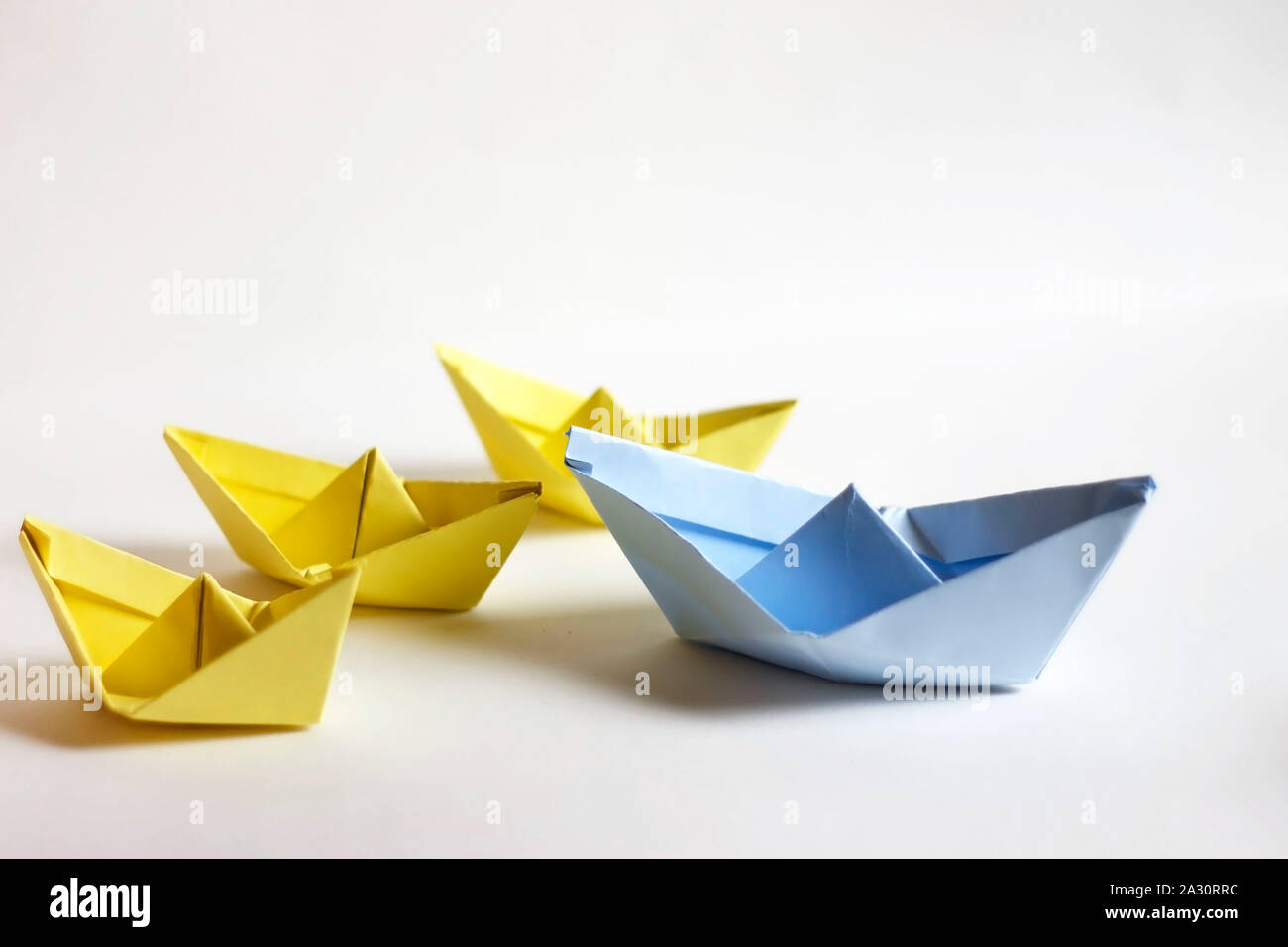 Leadership concept. Paper boats on a white background. Leader before ...