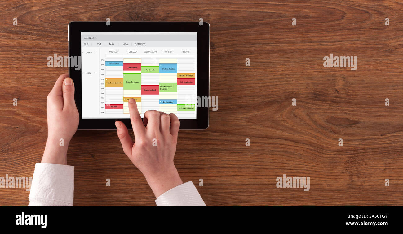 Hand holding tablet with timetable and calendar concept Stock Photo - Alamy