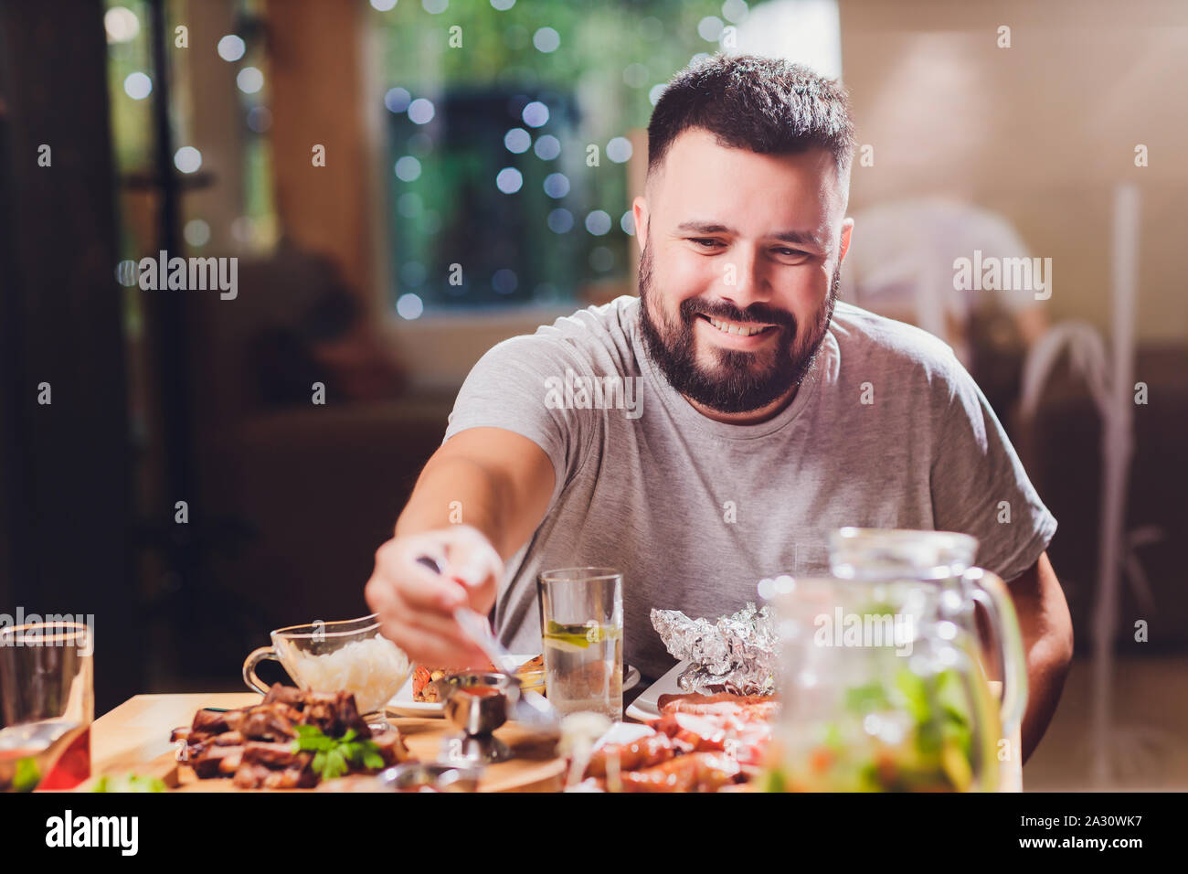 man at the big table with food Stock Photo - Alamy