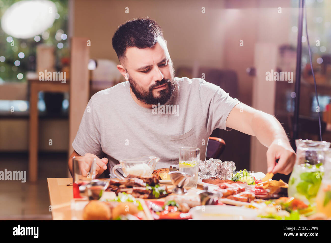 man at the big table with food Stock Photo - Alamy