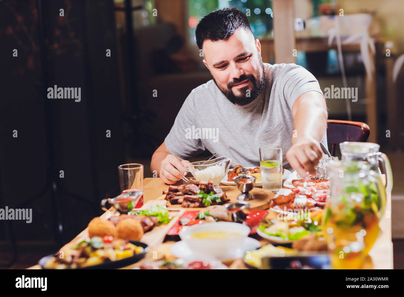 man at the big table with food Stock Photo - Alamy