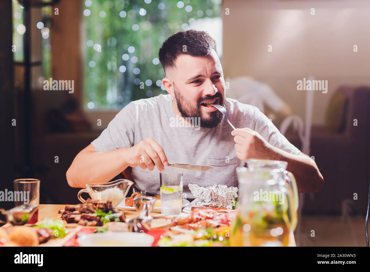 man at the big table with food Stock Photo - Alamy