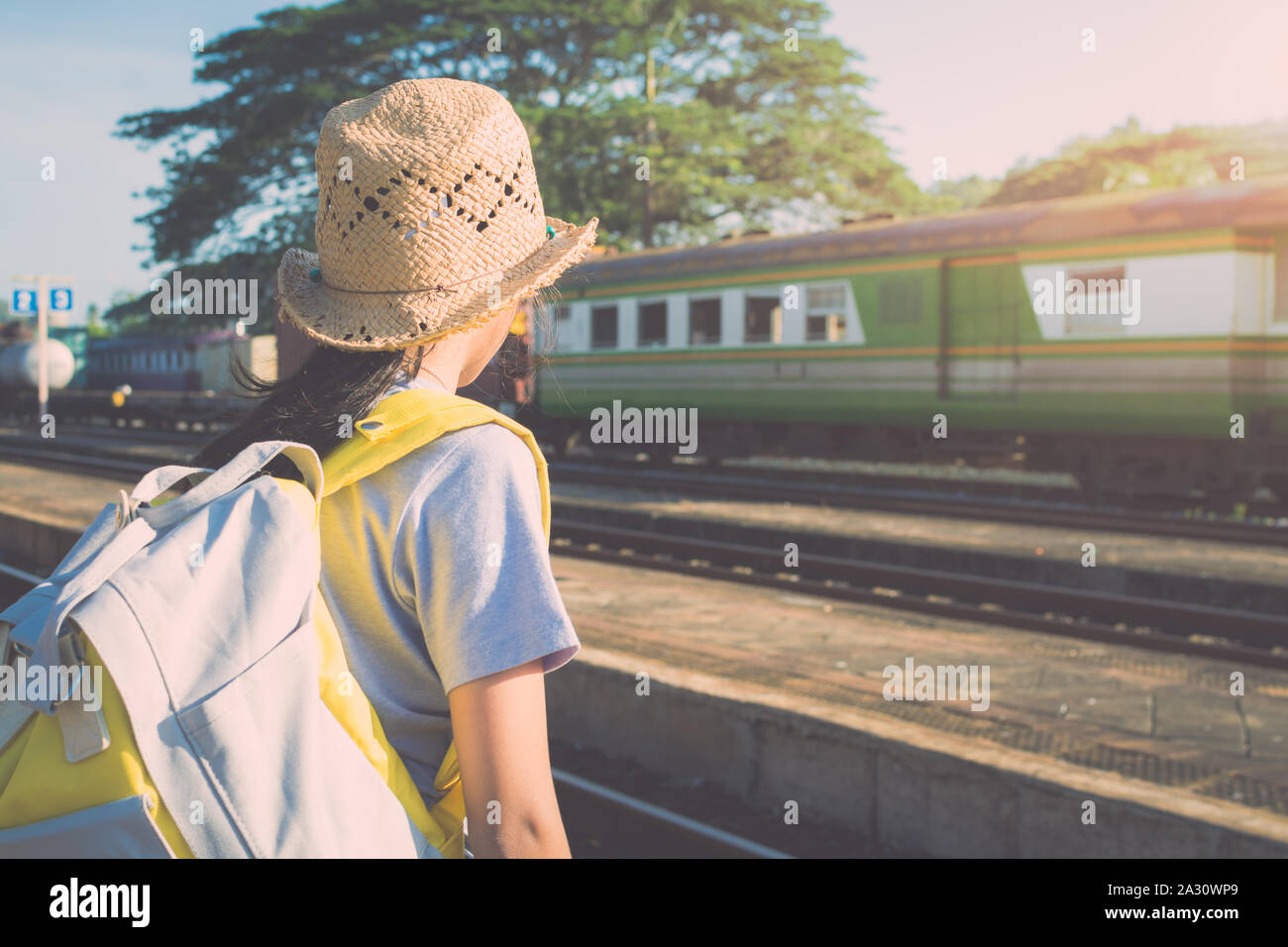 Young girl with bagpack waiting for a train at railway station in ...